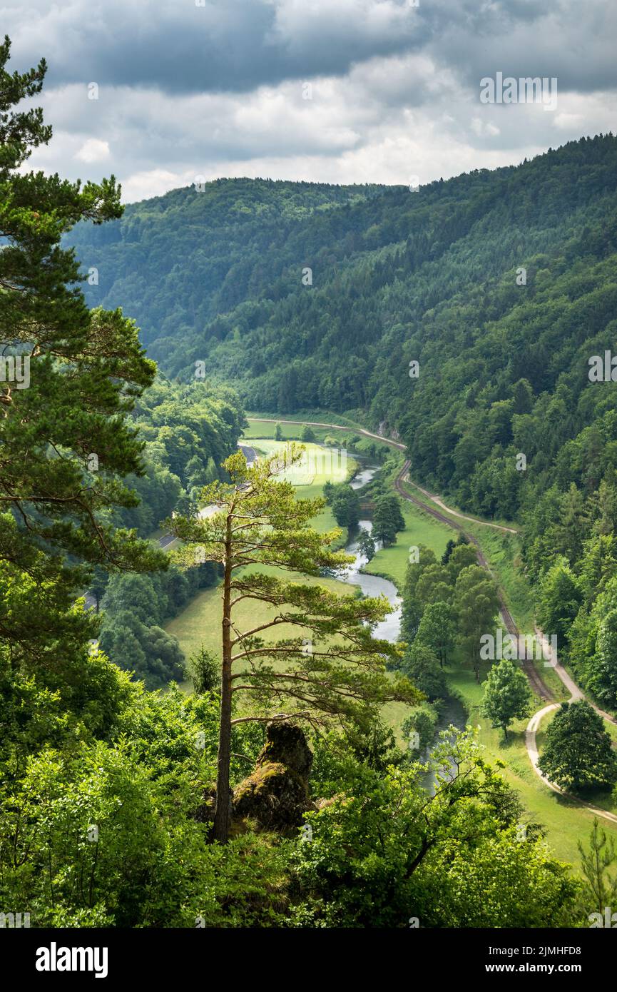 River running through green valley with curvy roads surrounded by ...