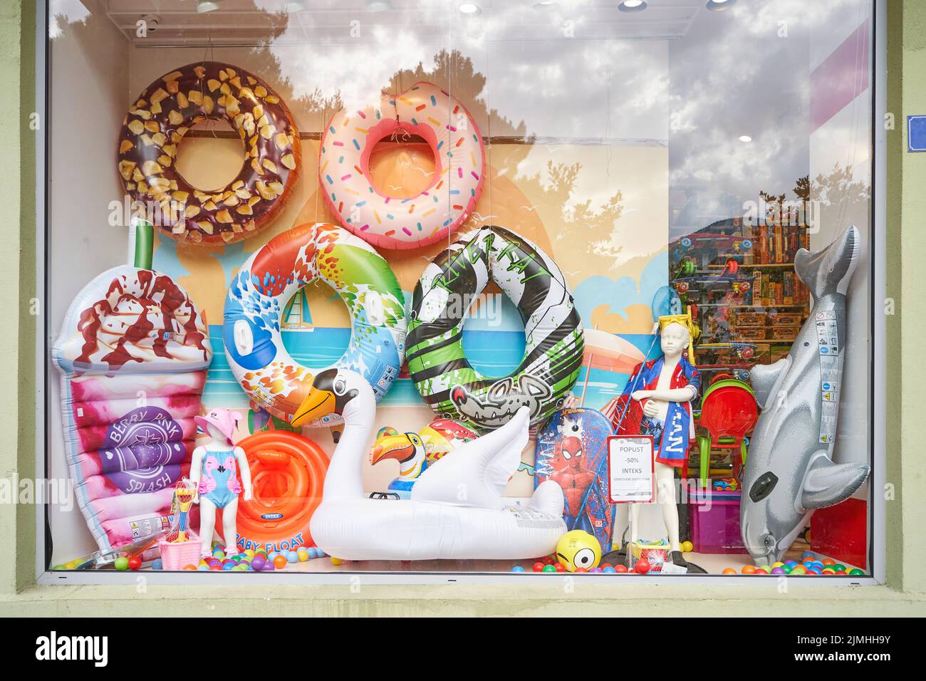 Shop window with inflatable rings and bathing products Stock Photo - Alamy