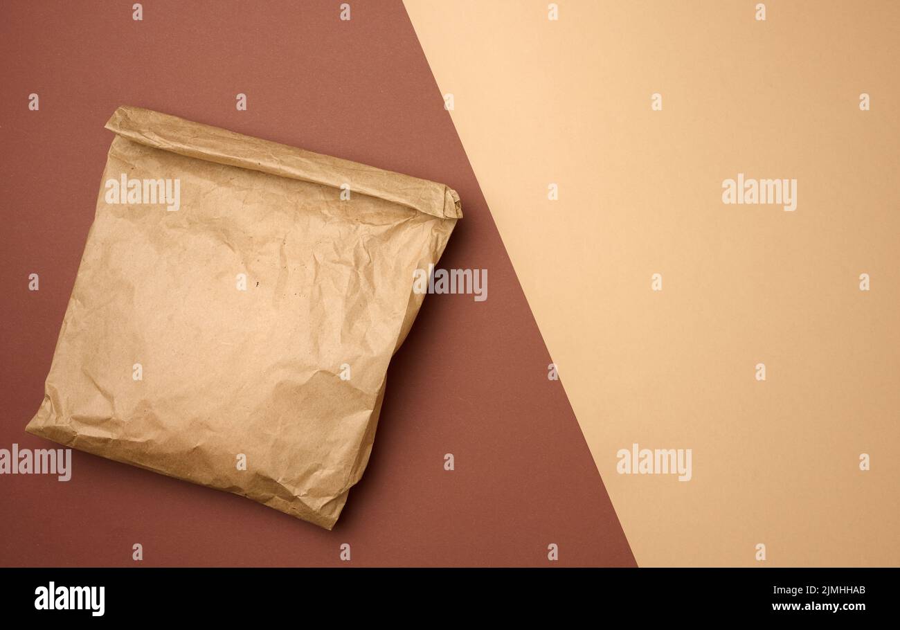 Full brown paper disposable food bag on a brown background, concept of ...