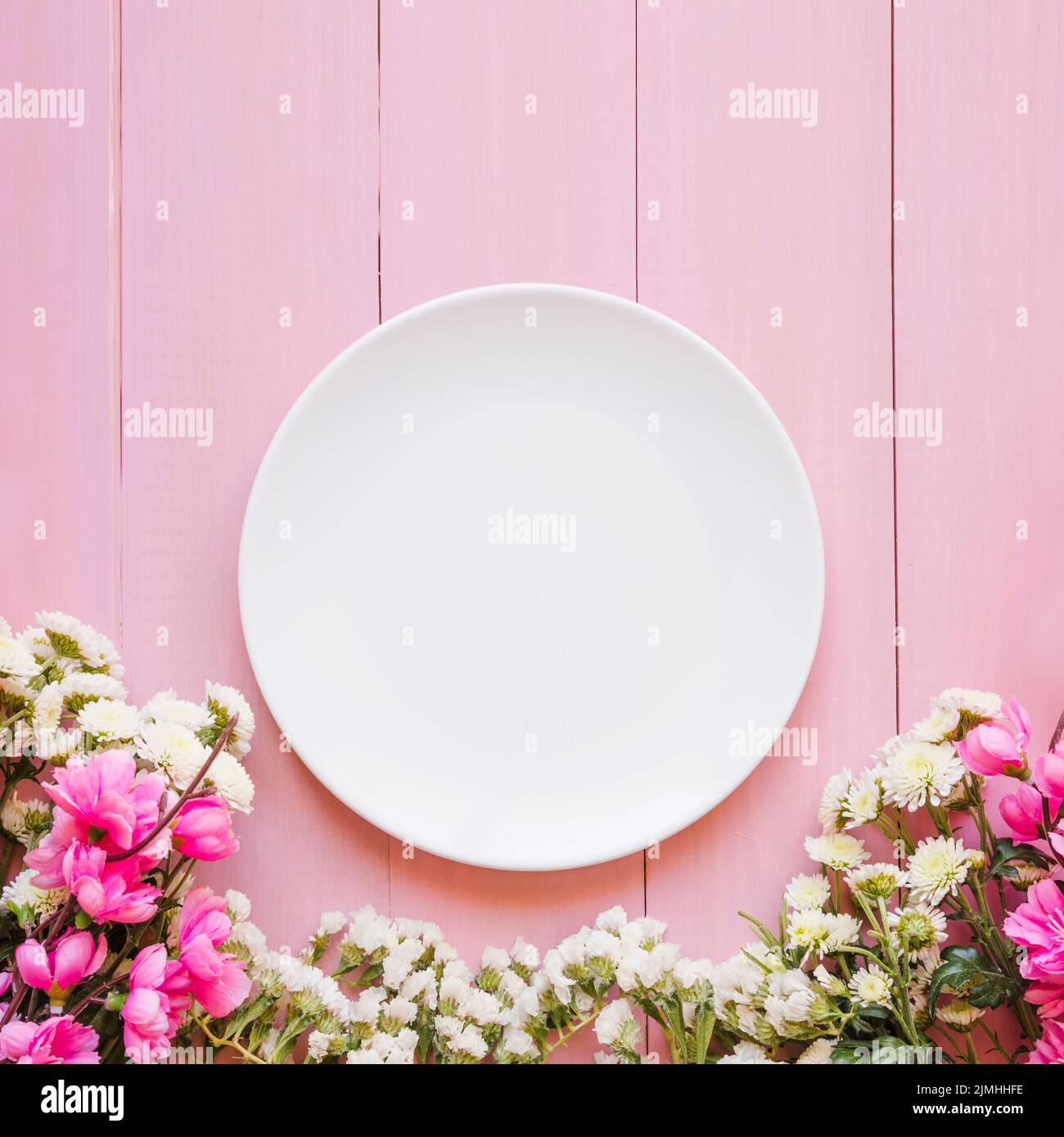 Pretty flowers near plate Stock Photo - Alamy