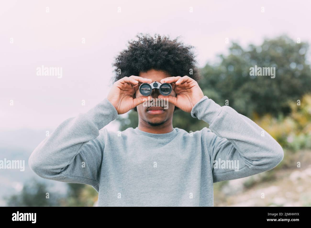 Man looking through binoculars Stock Photo - Alamy