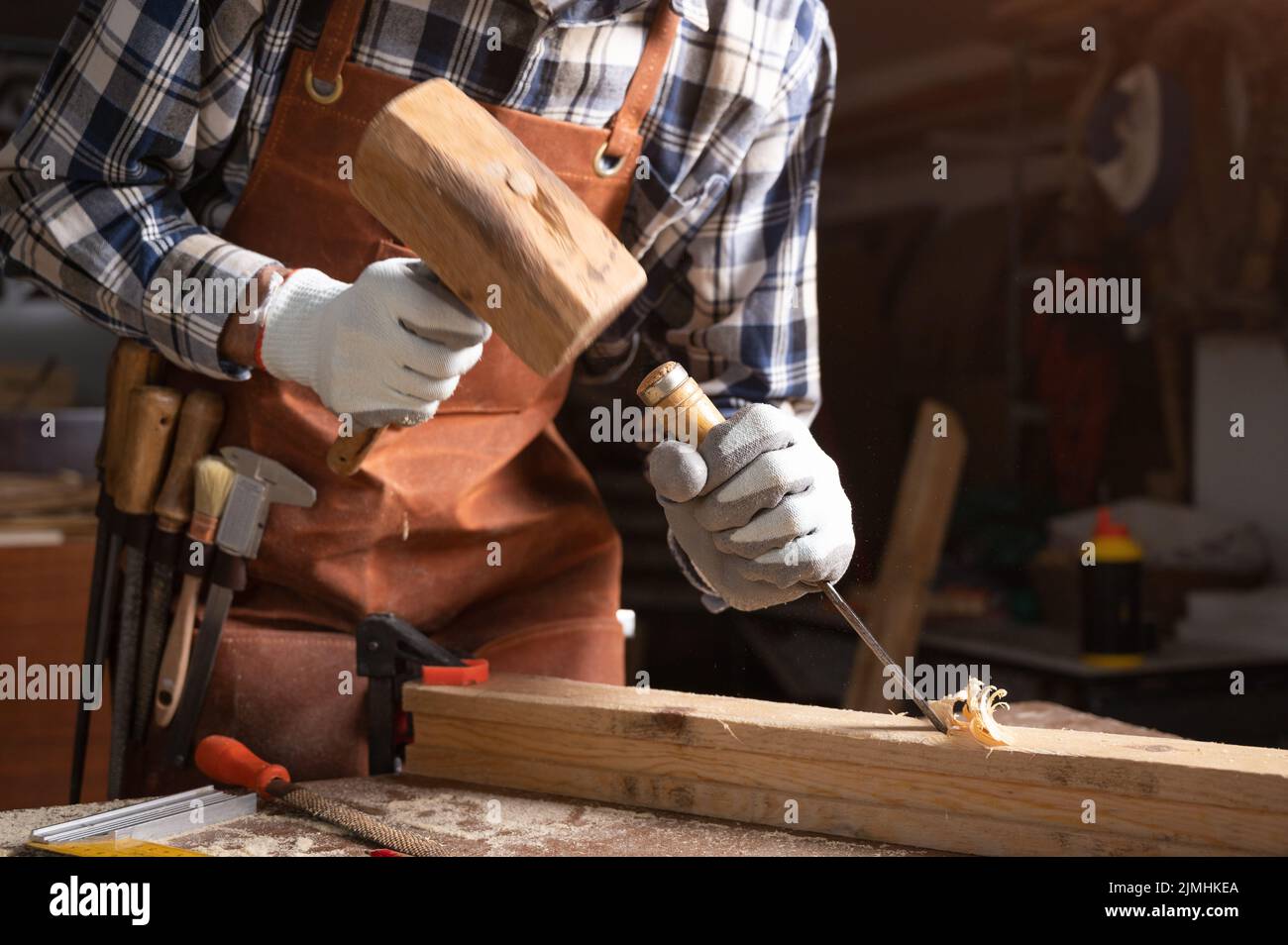 Skilled carpenter carving wood with hammer and chisel Stock Photo - Alamy