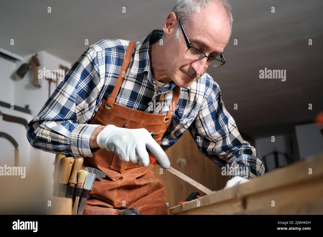 Carpenter filing a plank of wood in his Workshop Stock Photo - Alamy