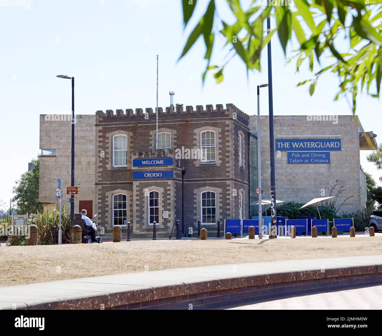 The Waterguard Public House, Cardiff Bay with man on electric ...