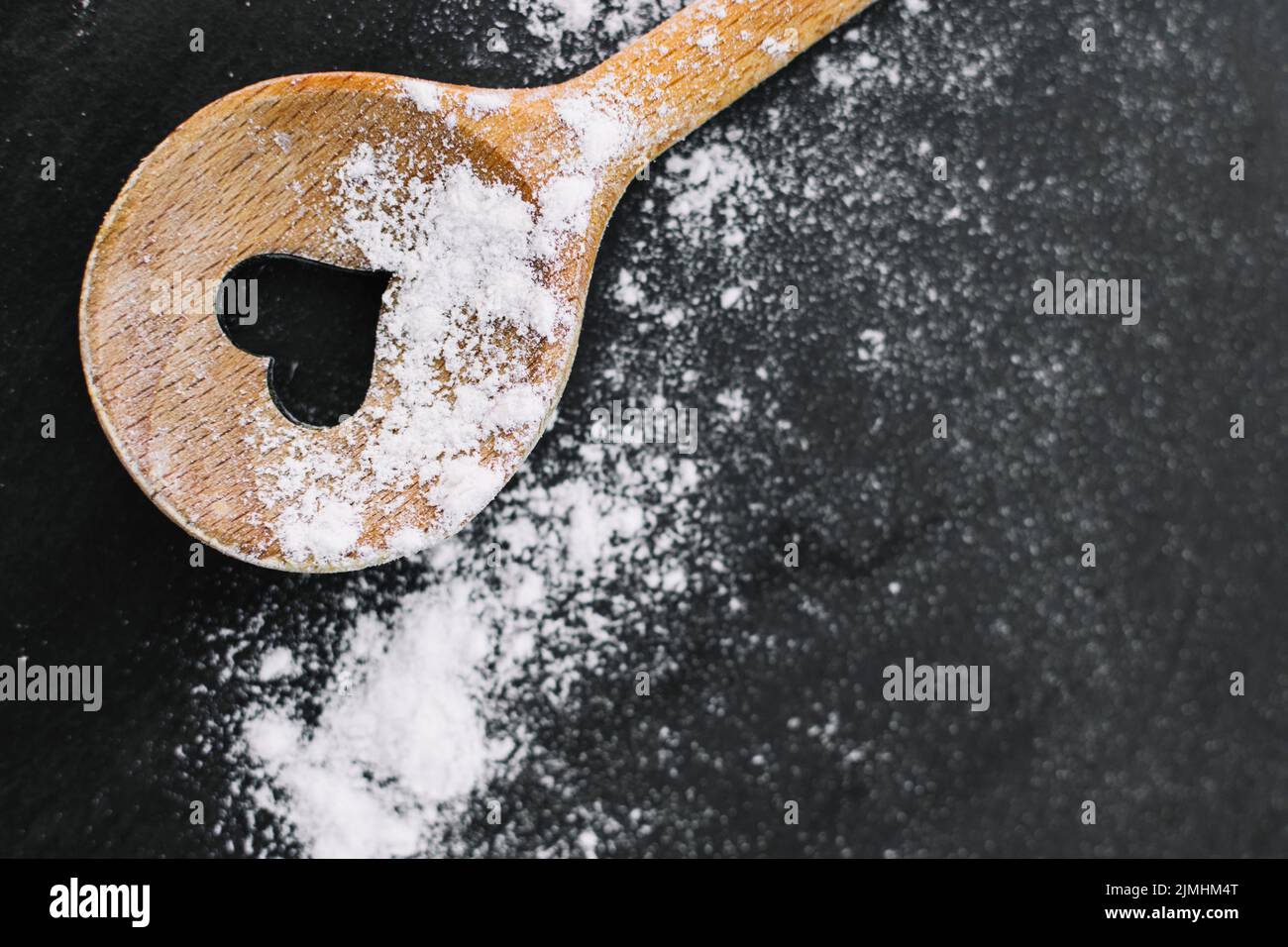 High angle view heart shape spoon flour black background Stock Photo ...