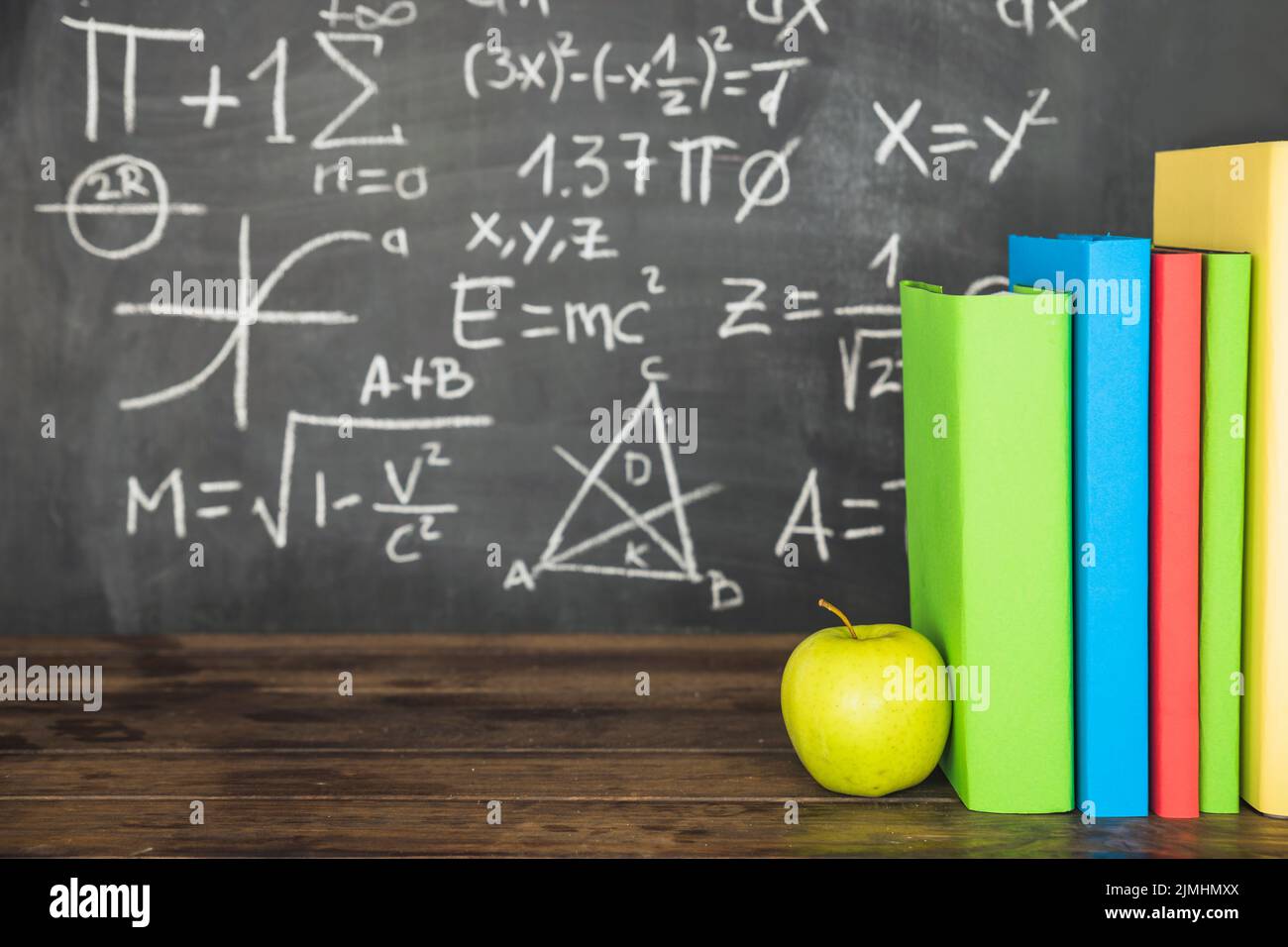 Books apple table near blackboard Stock Photo - Alamy