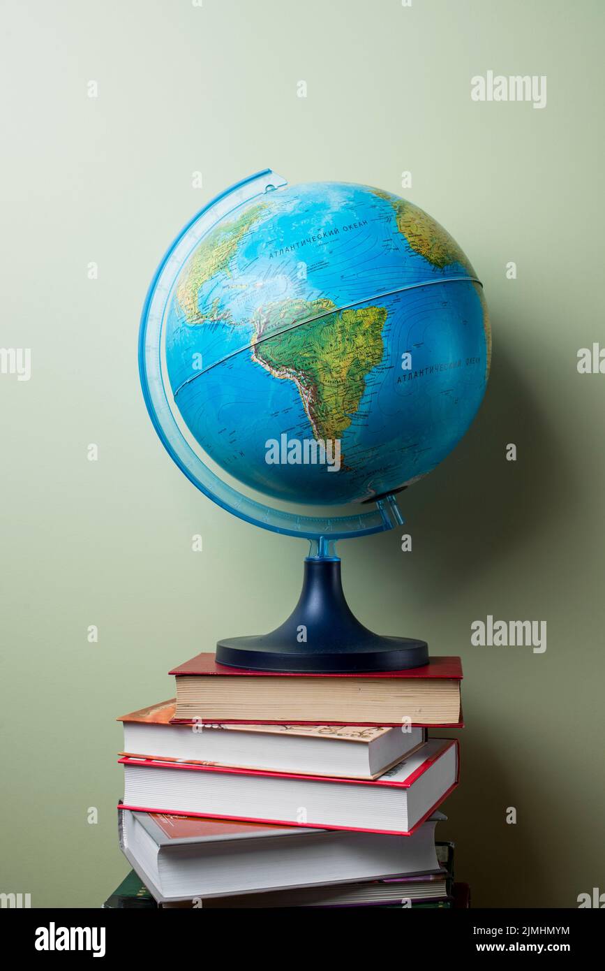 Stacked books with globe Stock Photo - Alamy