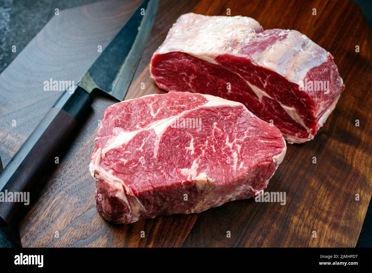Raw dry aged Angus rib-eye beef steaks offered as close-up on a modern ...
