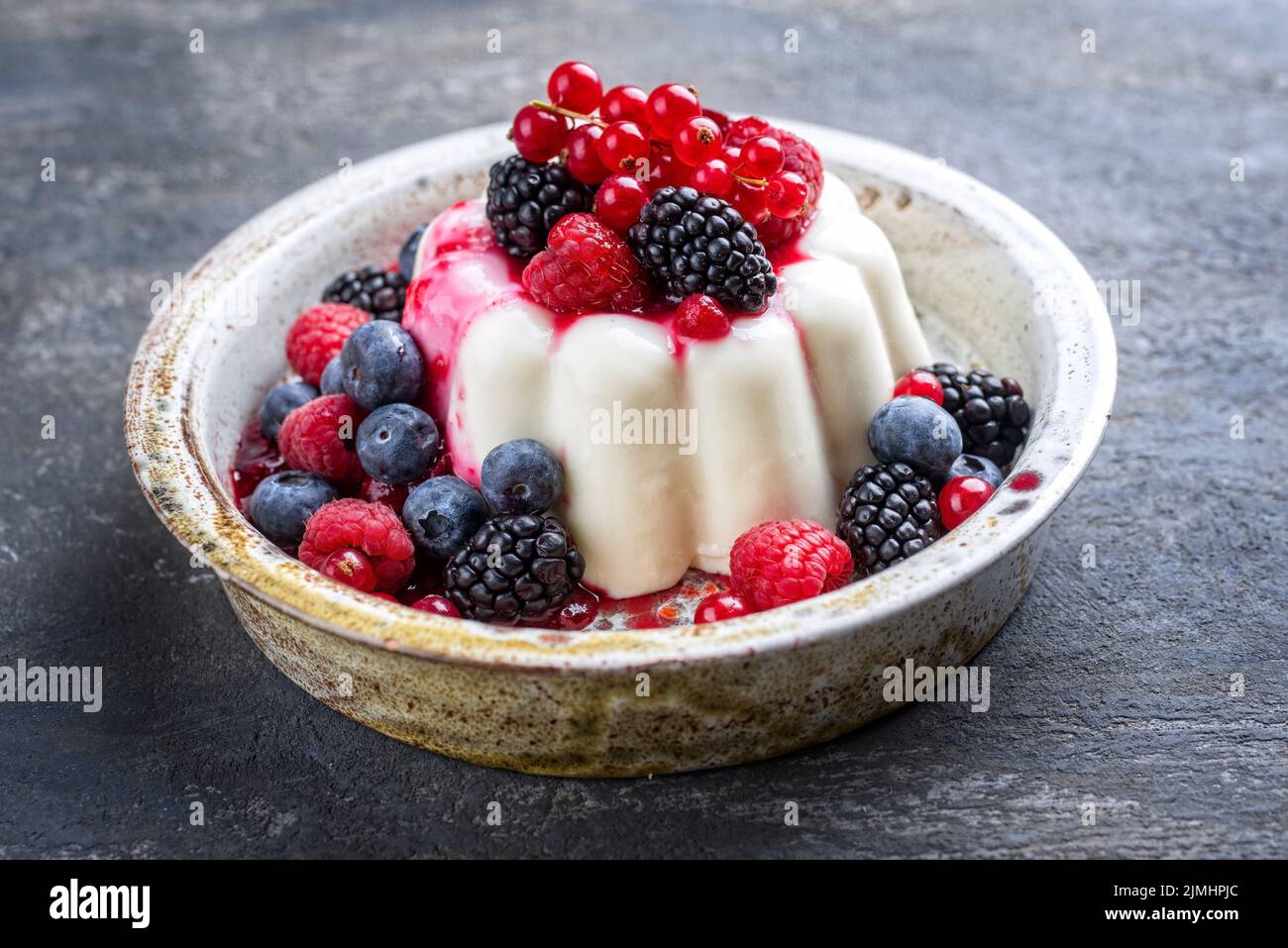 Modern style traditional blancmange almond pudding with wild berry ...