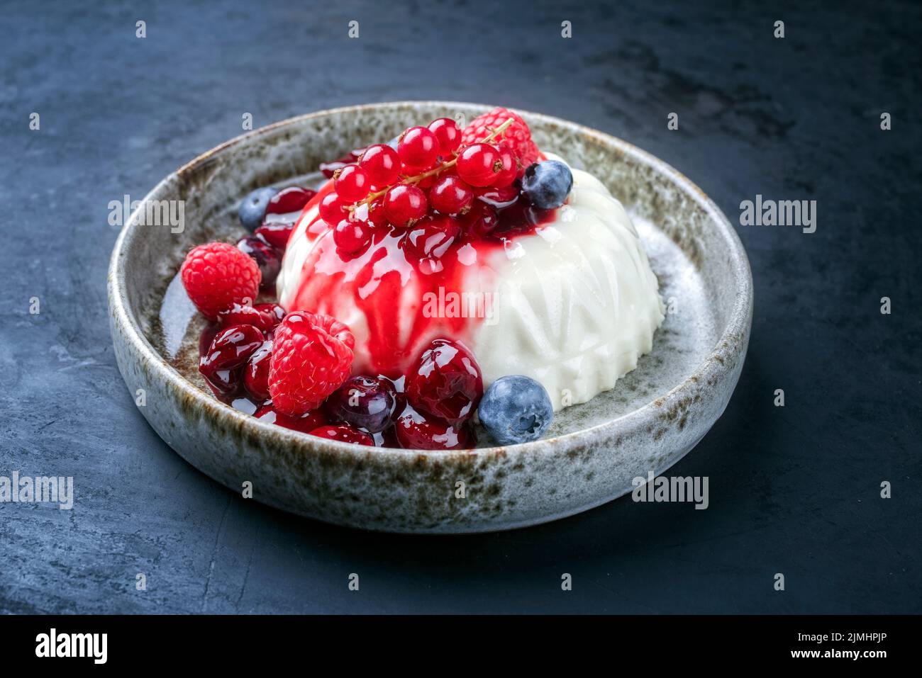 Modern style traditional blancmange almond pudding with wild berry ...