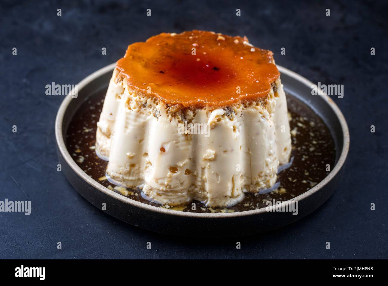 Modern style traditional creme caramel pudding served as close-up in a ...