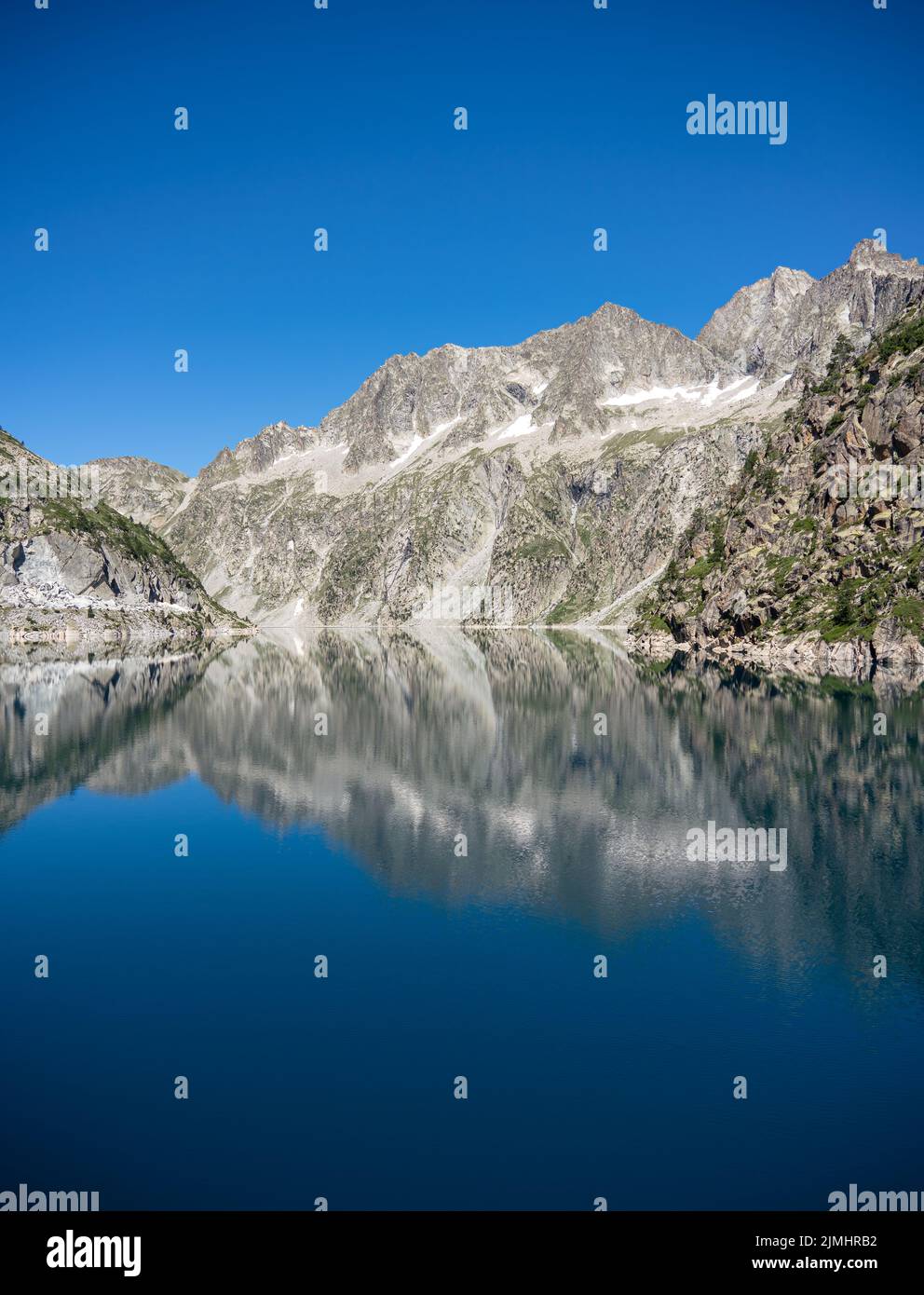 mountain reflection in still blue water lake, Lac de Cap-de-Long ...