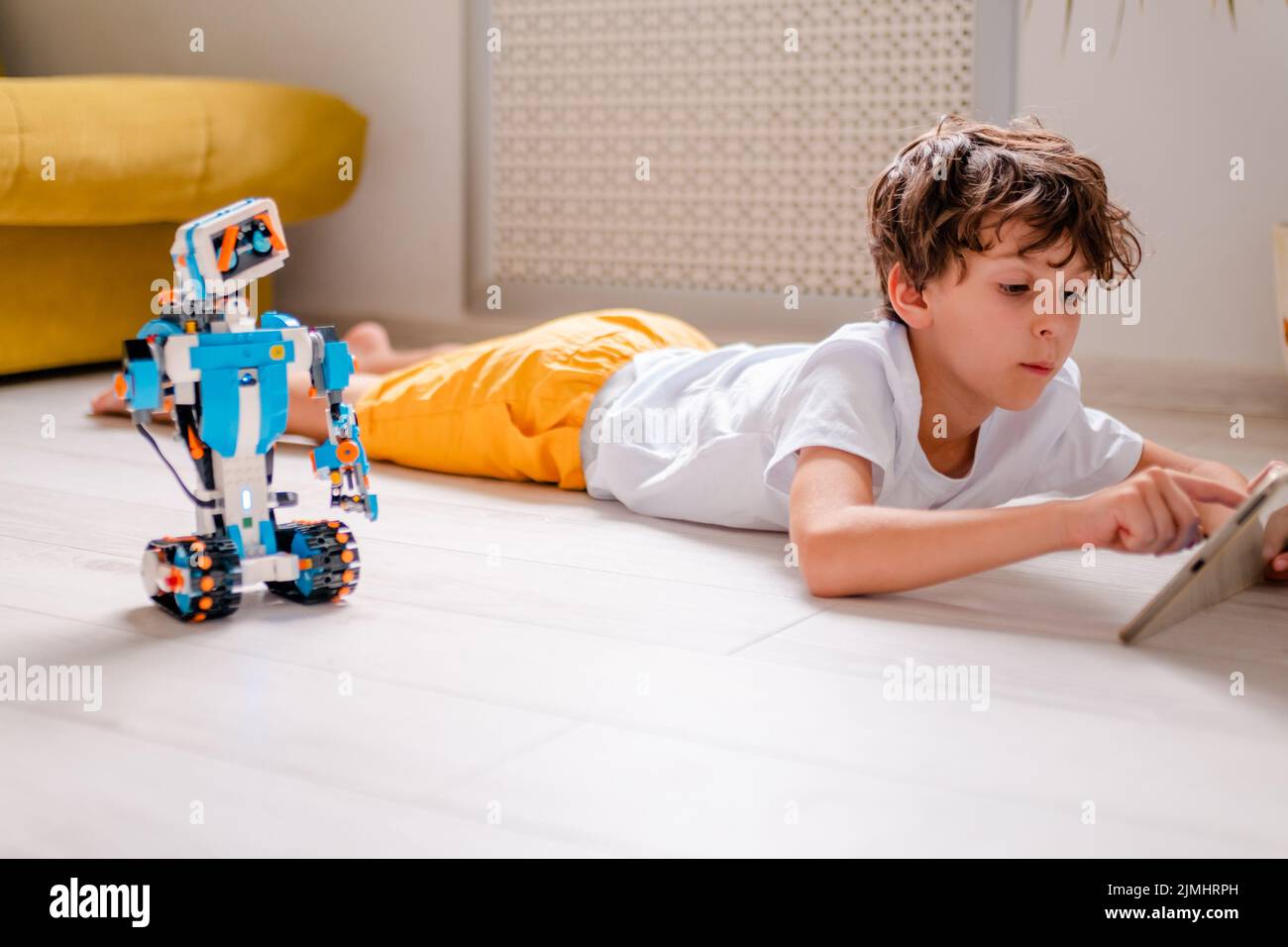 Kid programming robot from plastics details and programmed on tablet ...