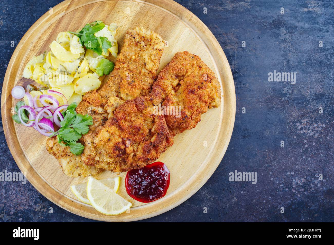 Traditional deep-fried schnitzel with potato salad Stock Photo - Alamy