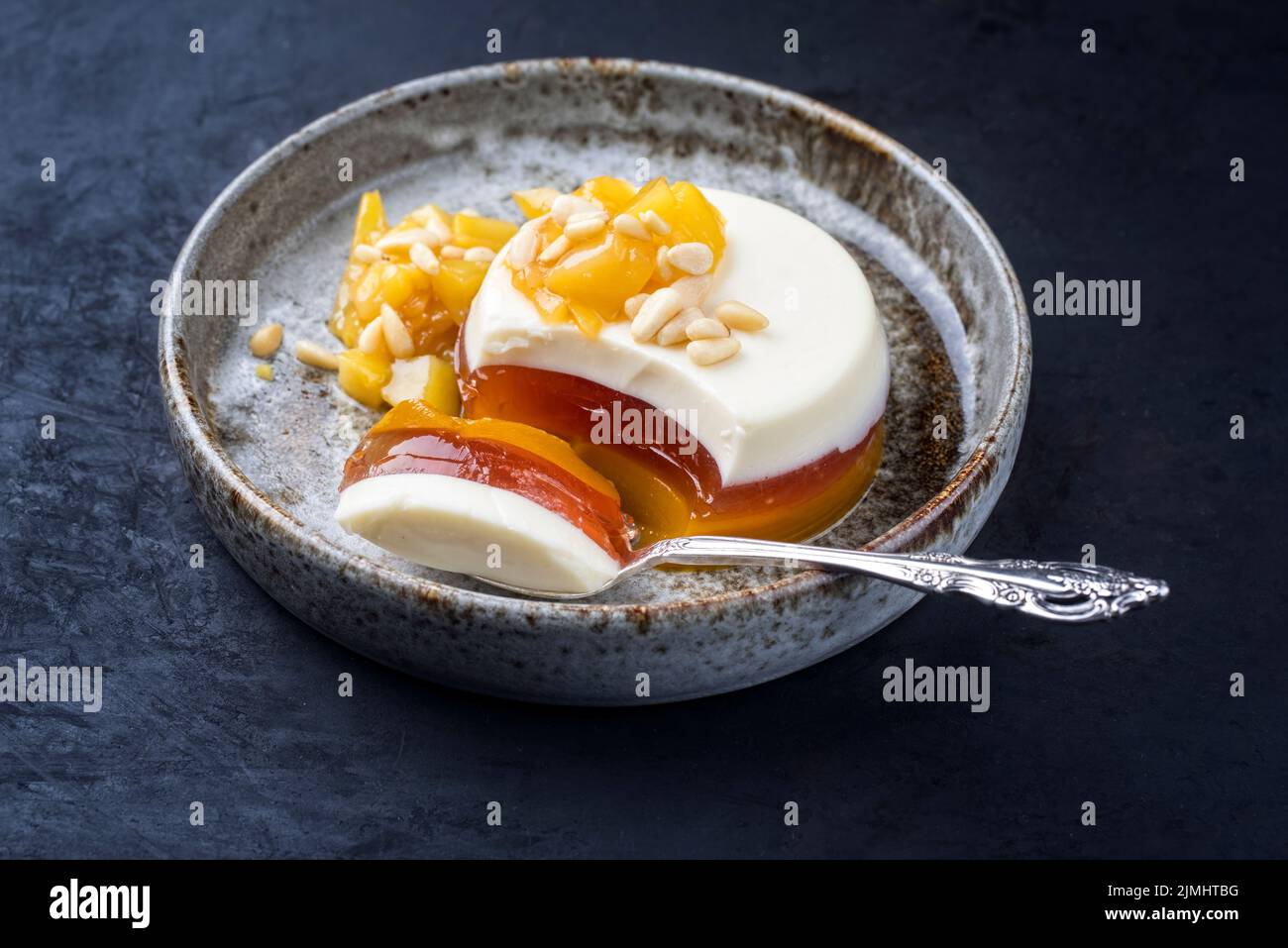 Modern style traditional blancmange almond pudding with mango compote ...