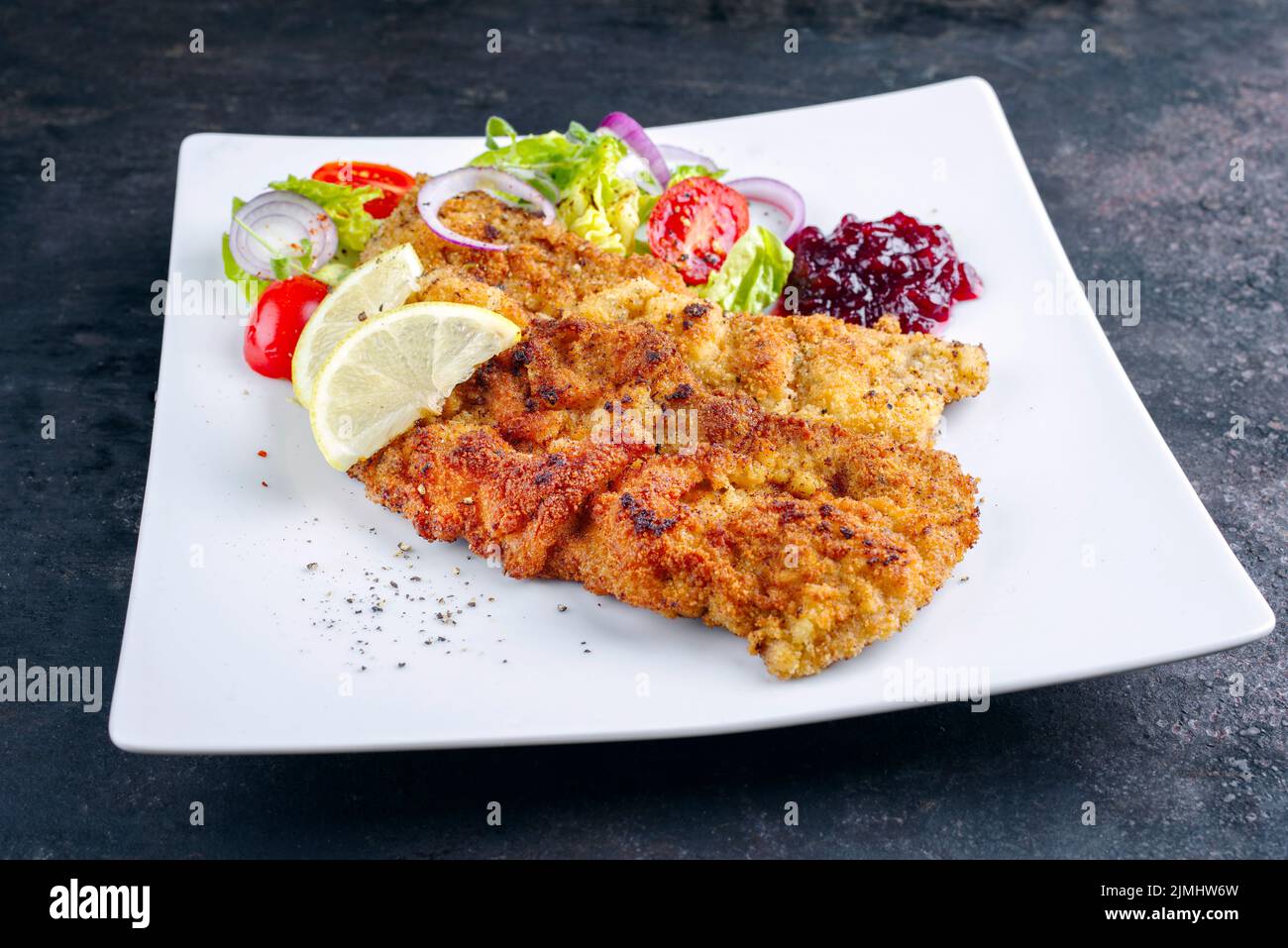 Traditional deep-fried schnitzel with green salad Stock Photo - Alamy