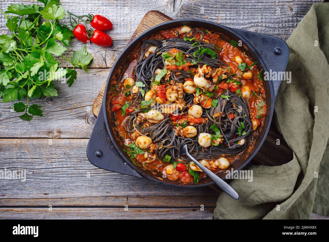 Traditional Italian spaghetti al nero di seppia with baby squid ink in ...
