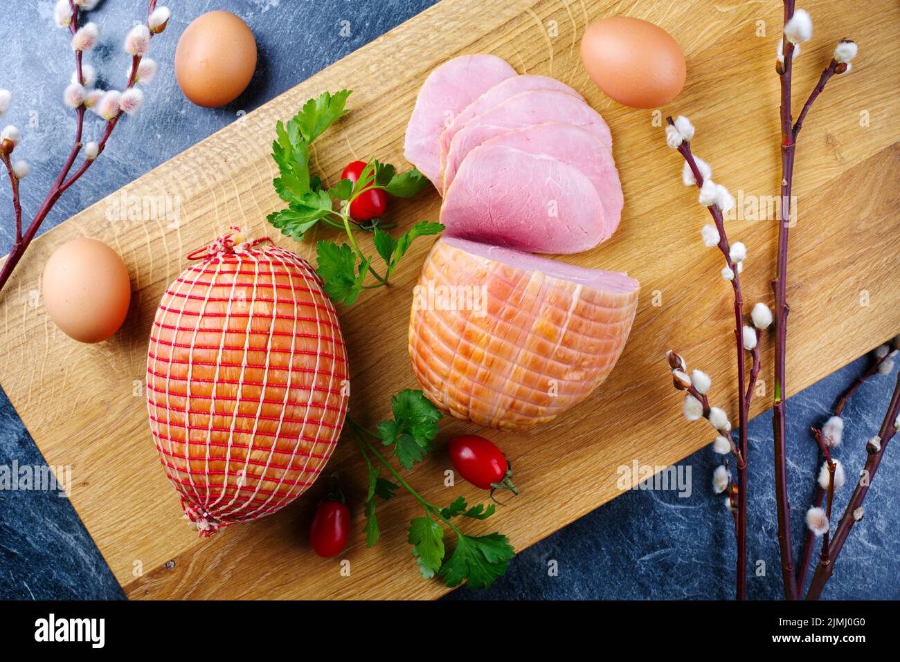 Traditional German boiled Easter ham with tomatoes and eggs offered as ...