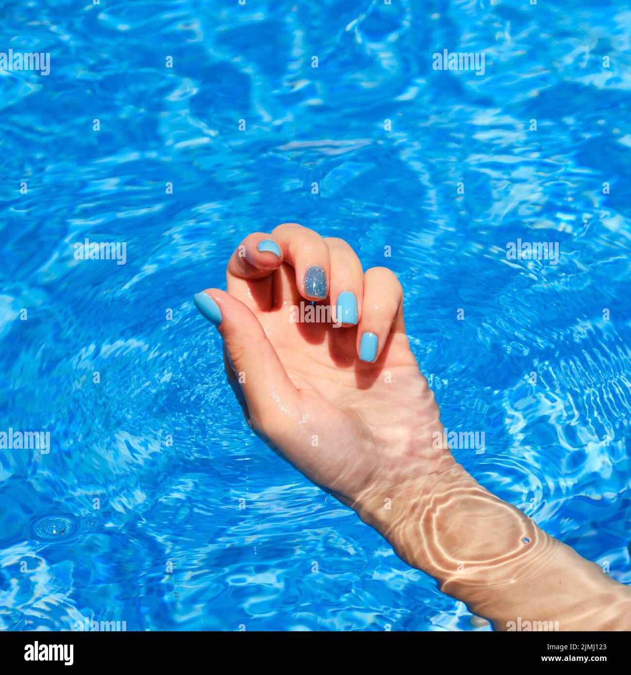 Female hands with bright manicure inside of water Stock Photo - Alamy
