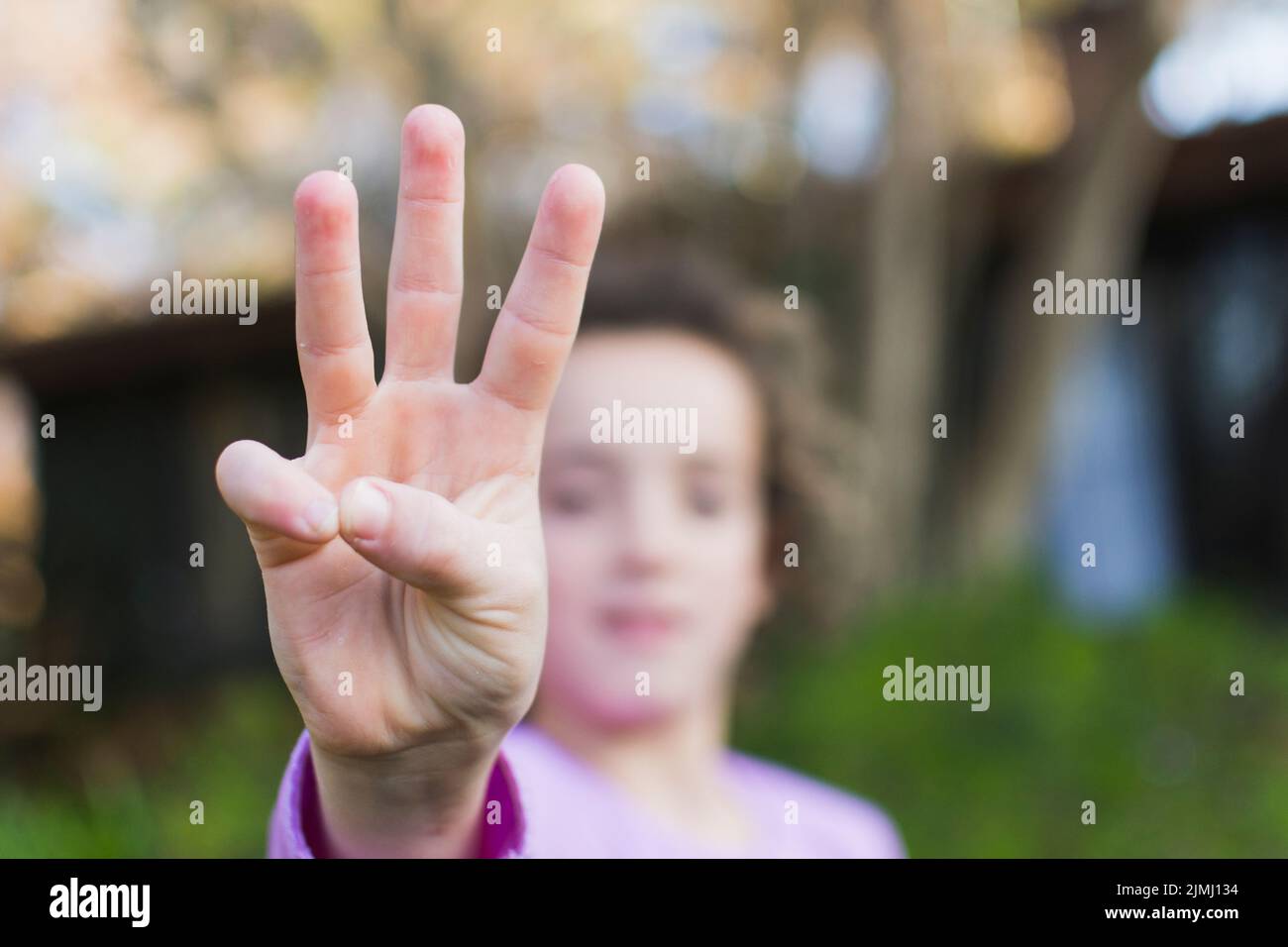Girl showing three finger salute hand gesture Stock Photo - Alamy