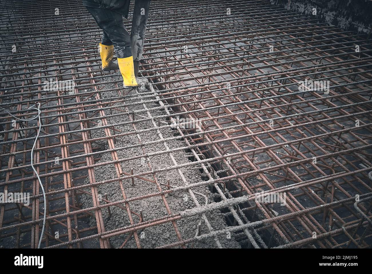 Construction worker is pouring concrete to formwork Stock Photo - Alamy