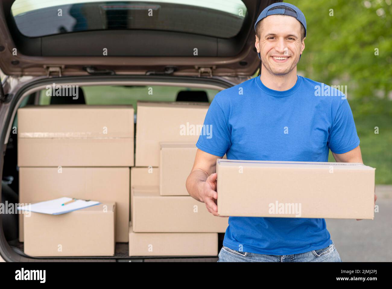 Smiley guy delivering box Stock Photo - Alamy
