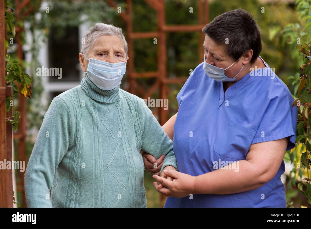 Female nurse taking care older woman with medical mask Stock Photo - Alamy