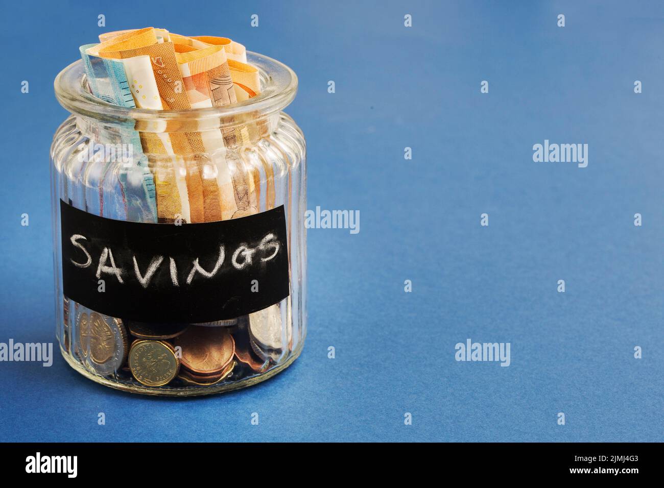 Saving bottle with euro notes coins blue background Stock Photo - Alamy