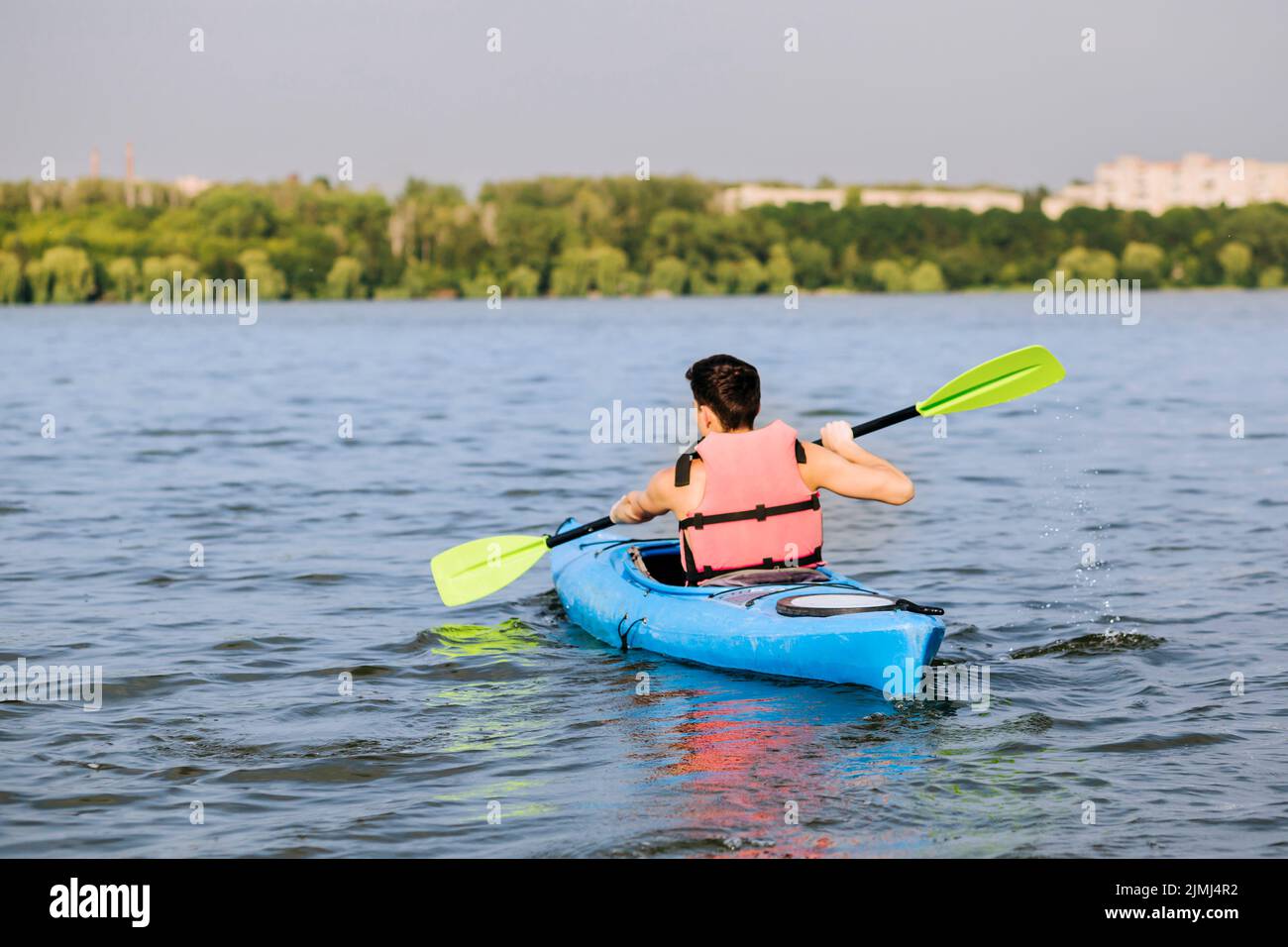 Rear view man using paddle kayaking Stock Photo - Alamy