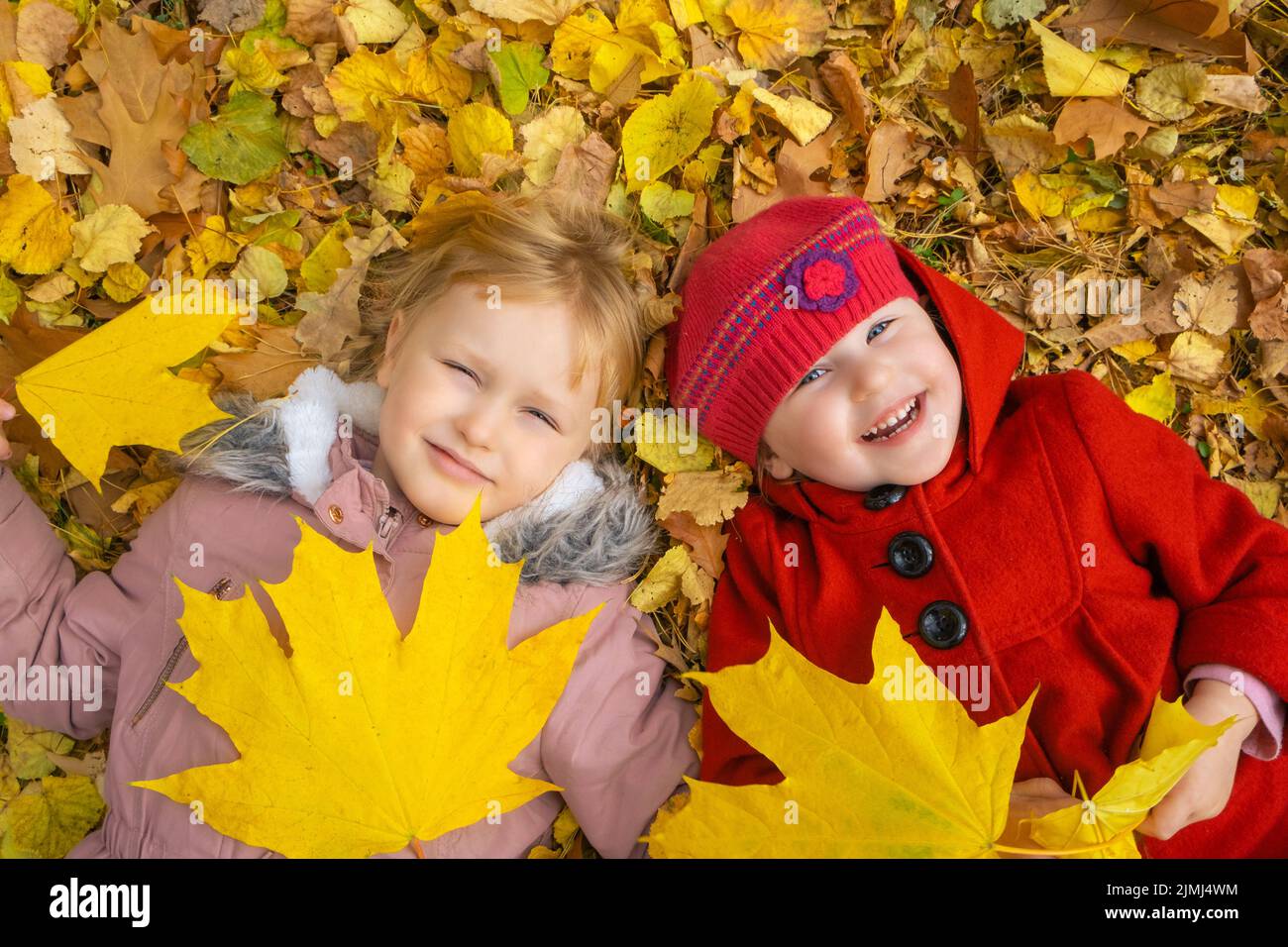 Adorable toddler kids lieing on the ground and playing with yellow ...