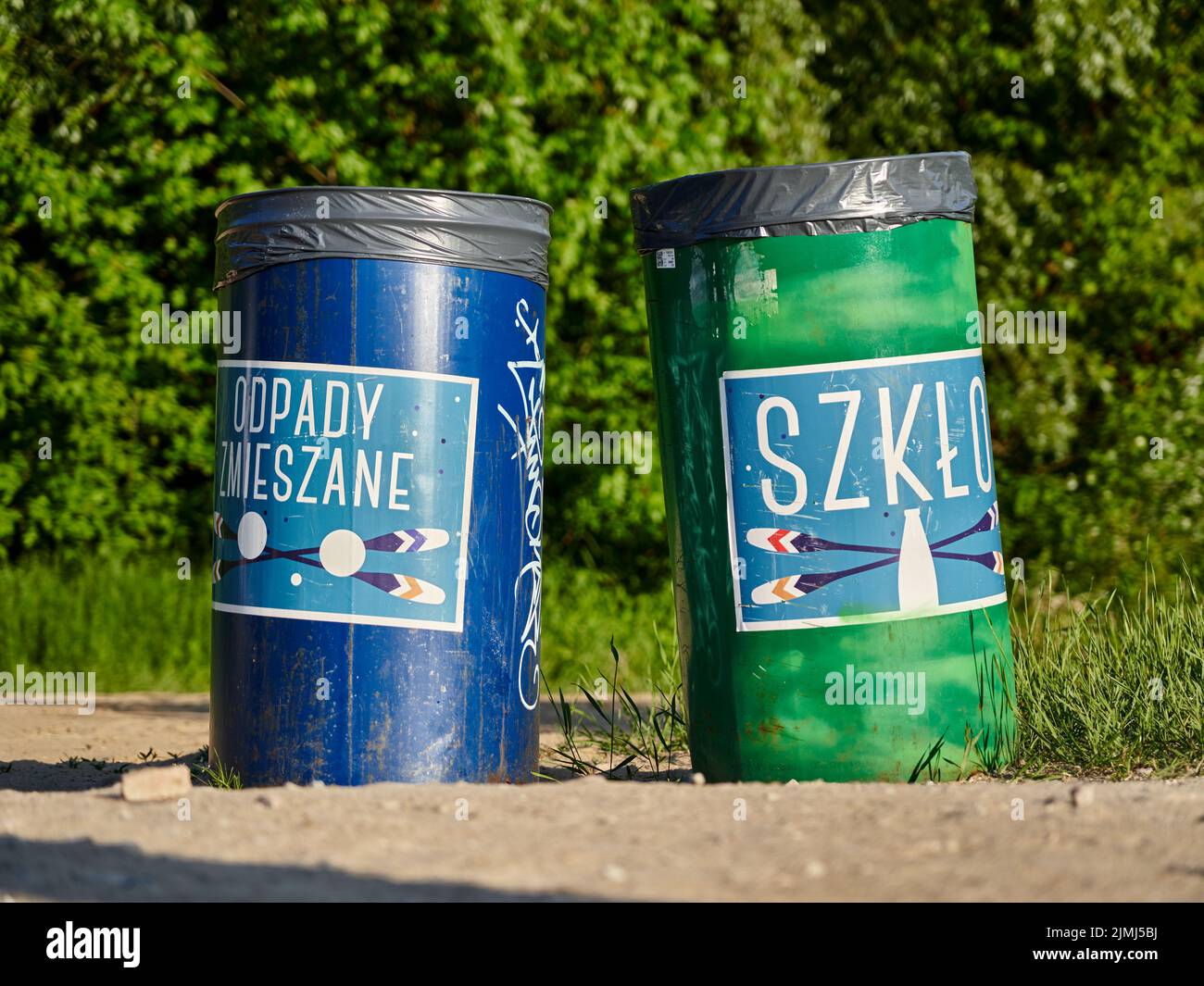 A Polish mixed waste sign on a blue trash container and a glass sign on ...