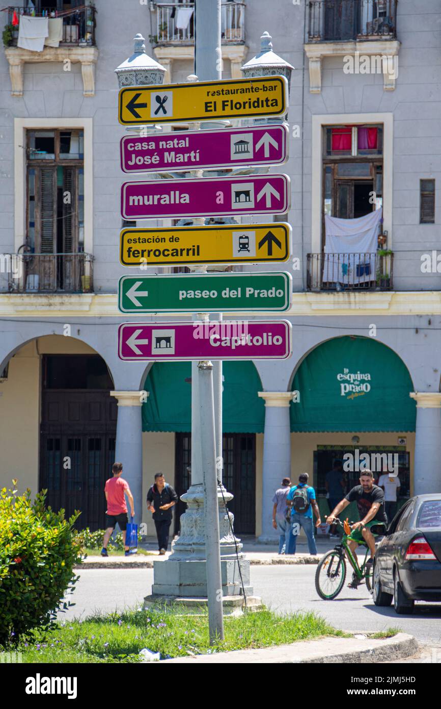 A pole with a list of signs showing various tourist sites in and around ...