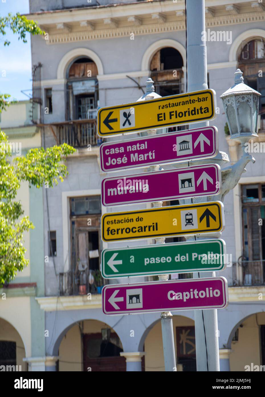 A pole with a list of signs showing various tourist sites in and around ...