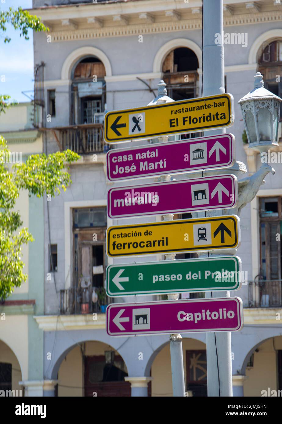 A pole with a list of signs showing various tourist sites in and around ...