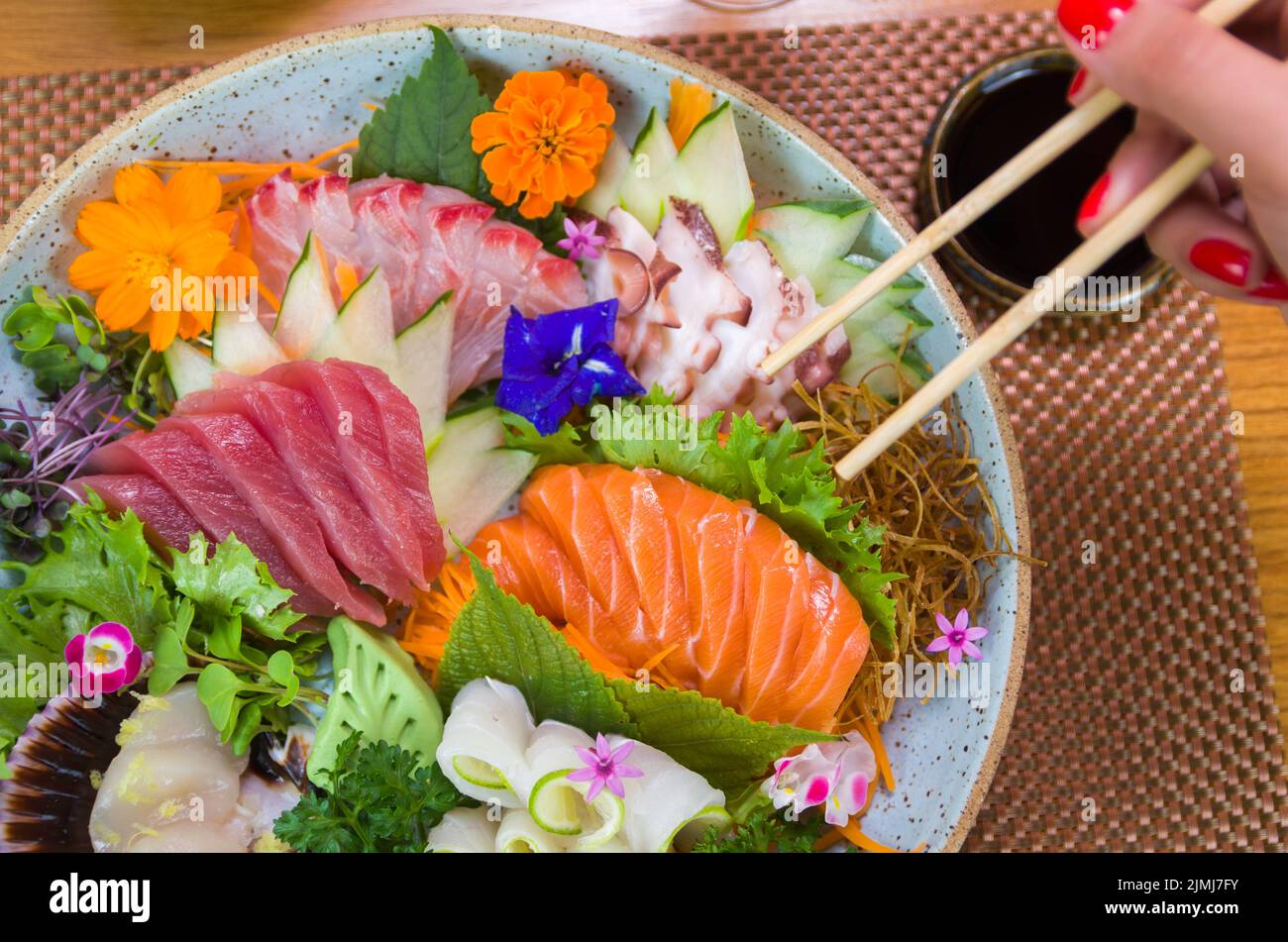 Woman eating delicious sashimi, closeup on chopsticks Stock Photo - Alamy