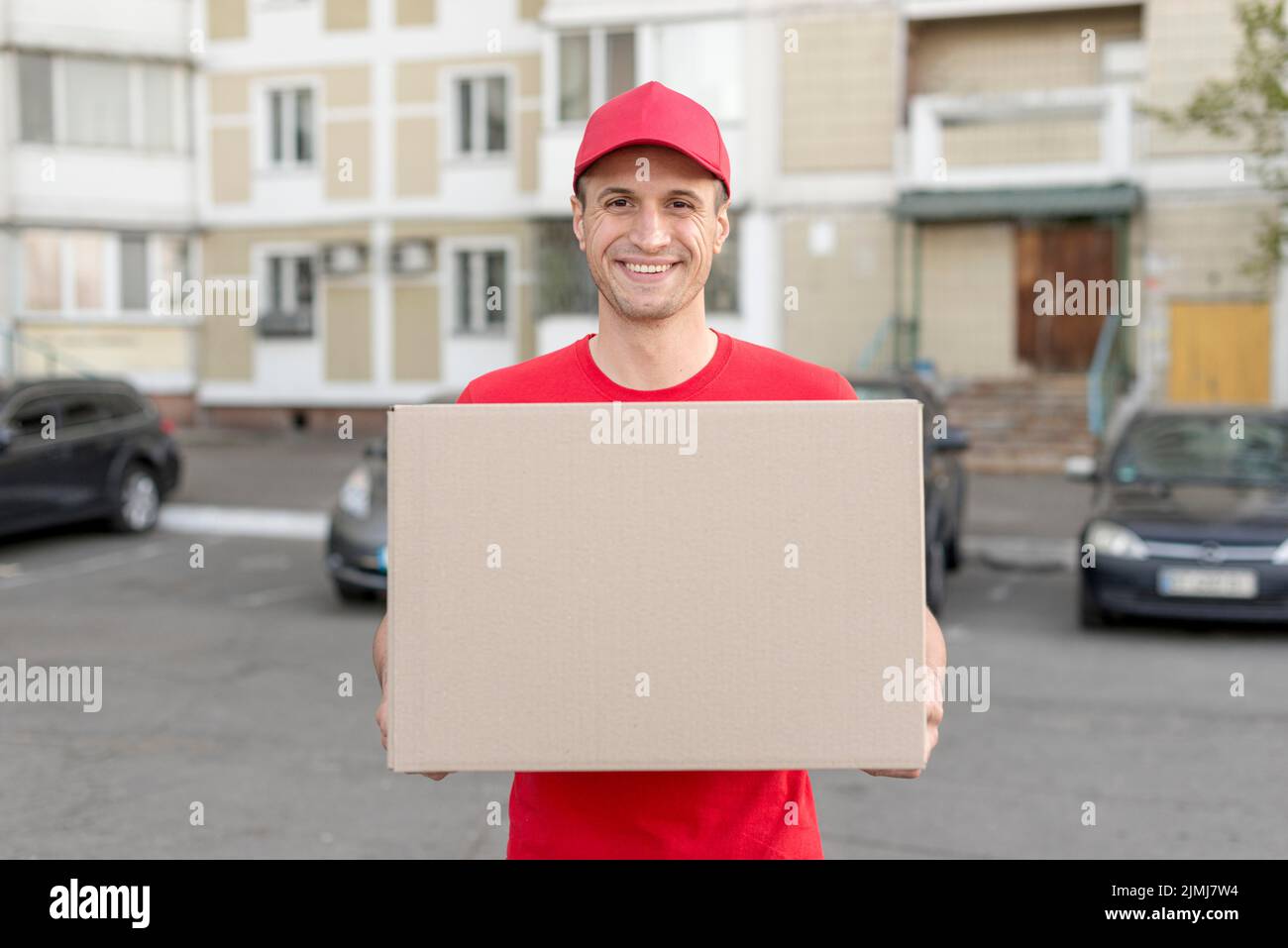 Smiley guy delivering package Stock Photo - Alamy