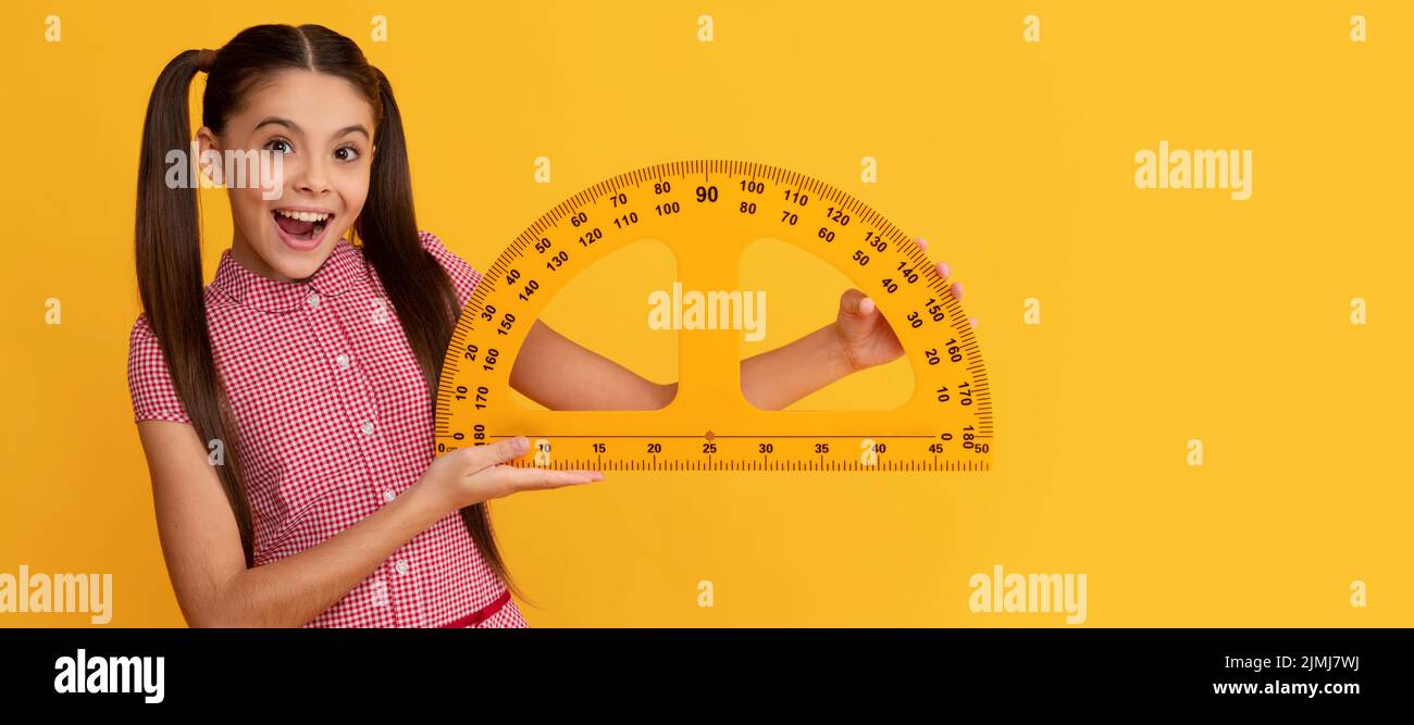 amazed kid hold school math tool protractor ruler on yellow background ...