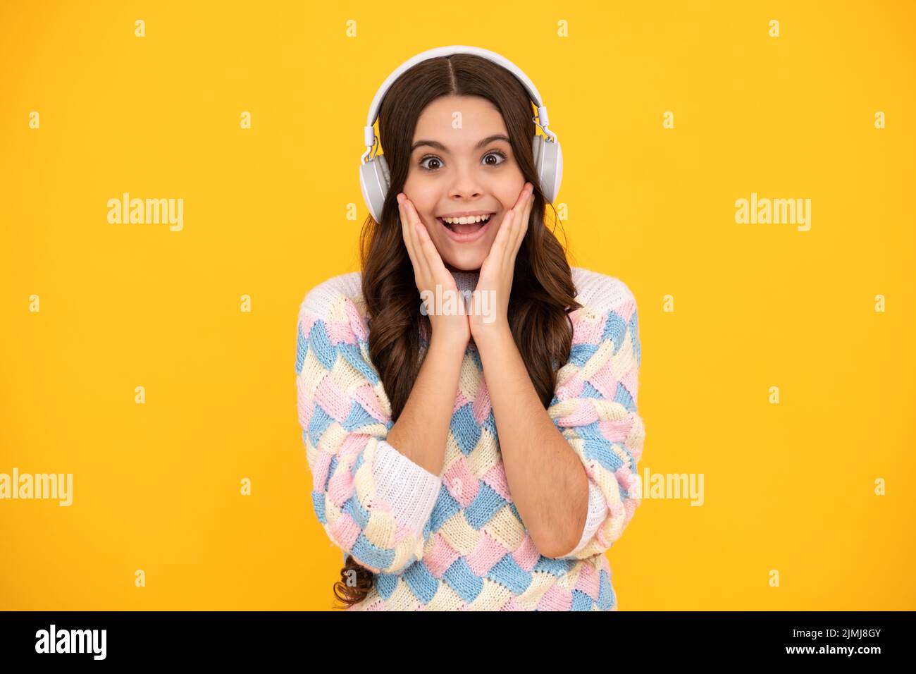 Excited face. Teenager child girl in headphones listening music ...