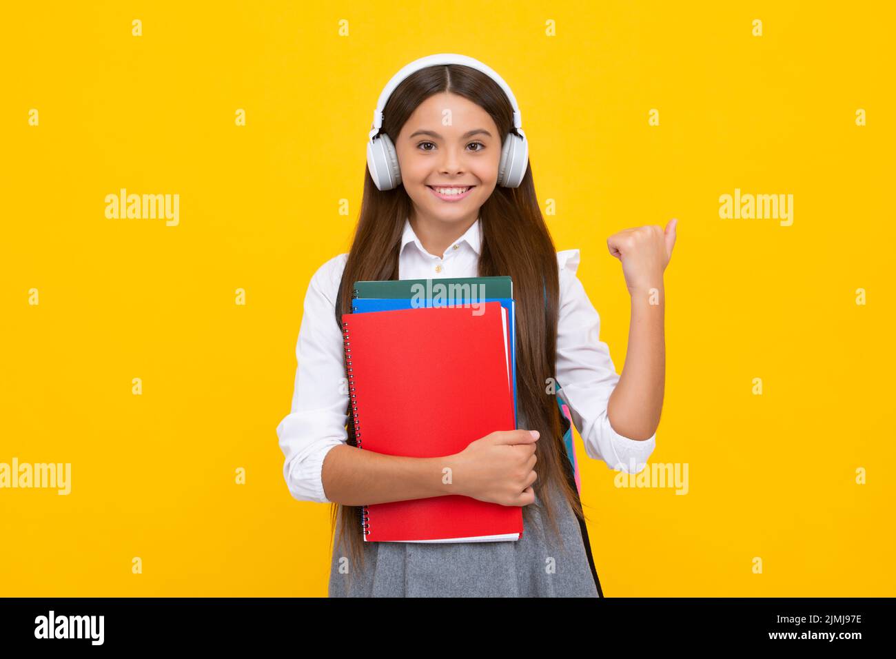 School teen girl in headphones hold book notebooks. Listen to music ...