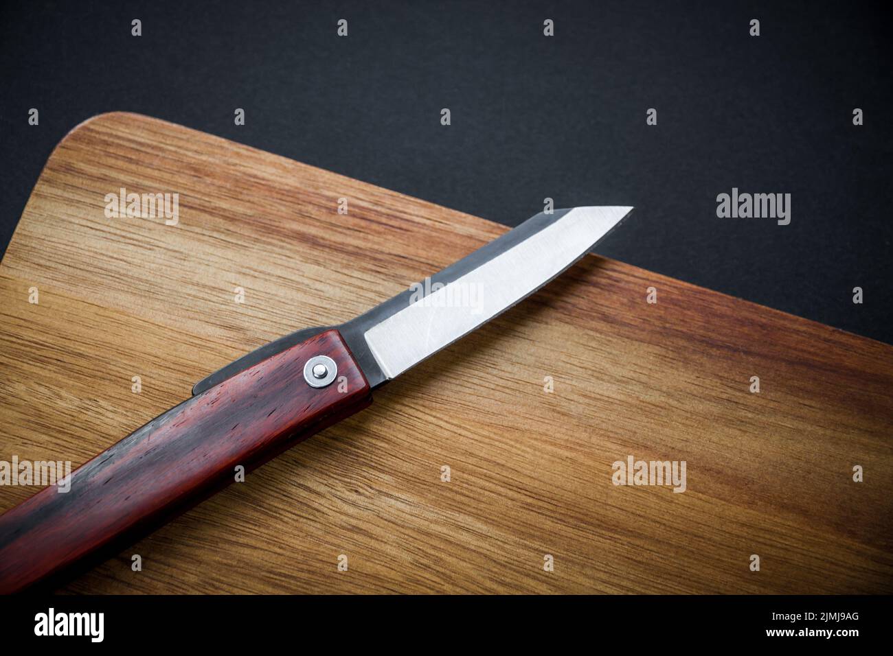 Traditional japanese pocket knife on a wooden cutting board Stock Photo ...