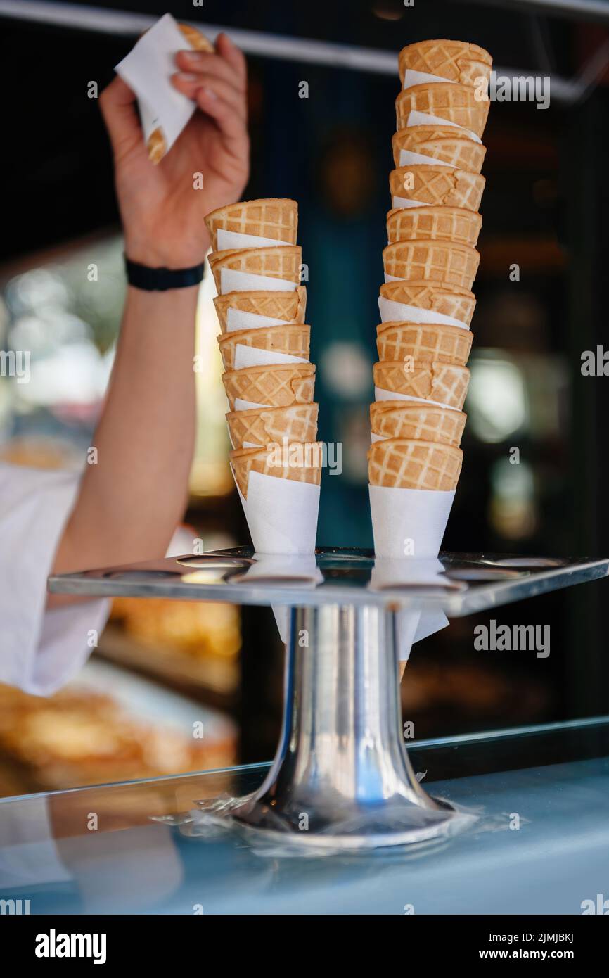 Seller preparing wafer made ice cream cone, poke at the delicious ...