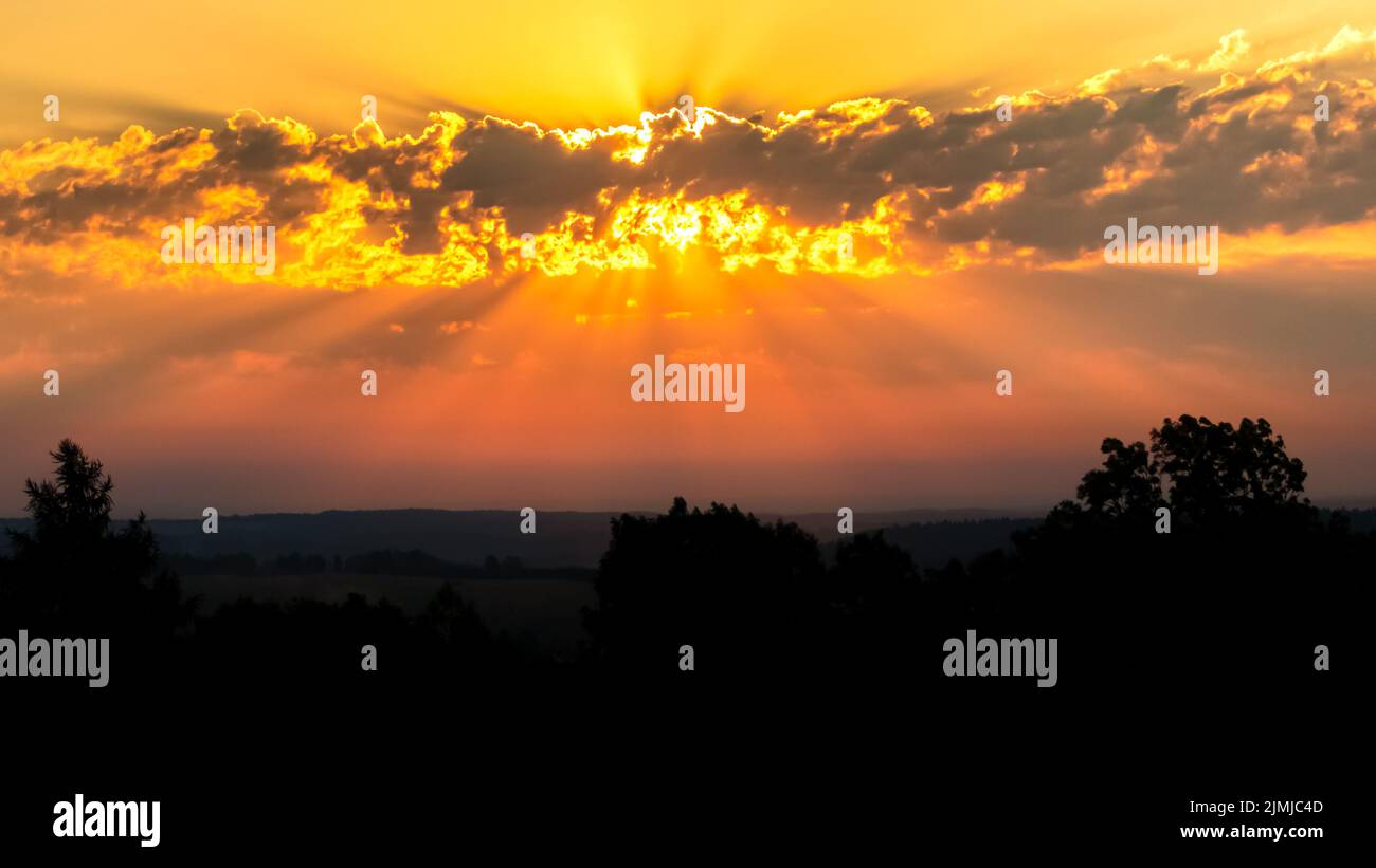 Crimson sunrise (sunset) bright rays of the sun breaking through the ...