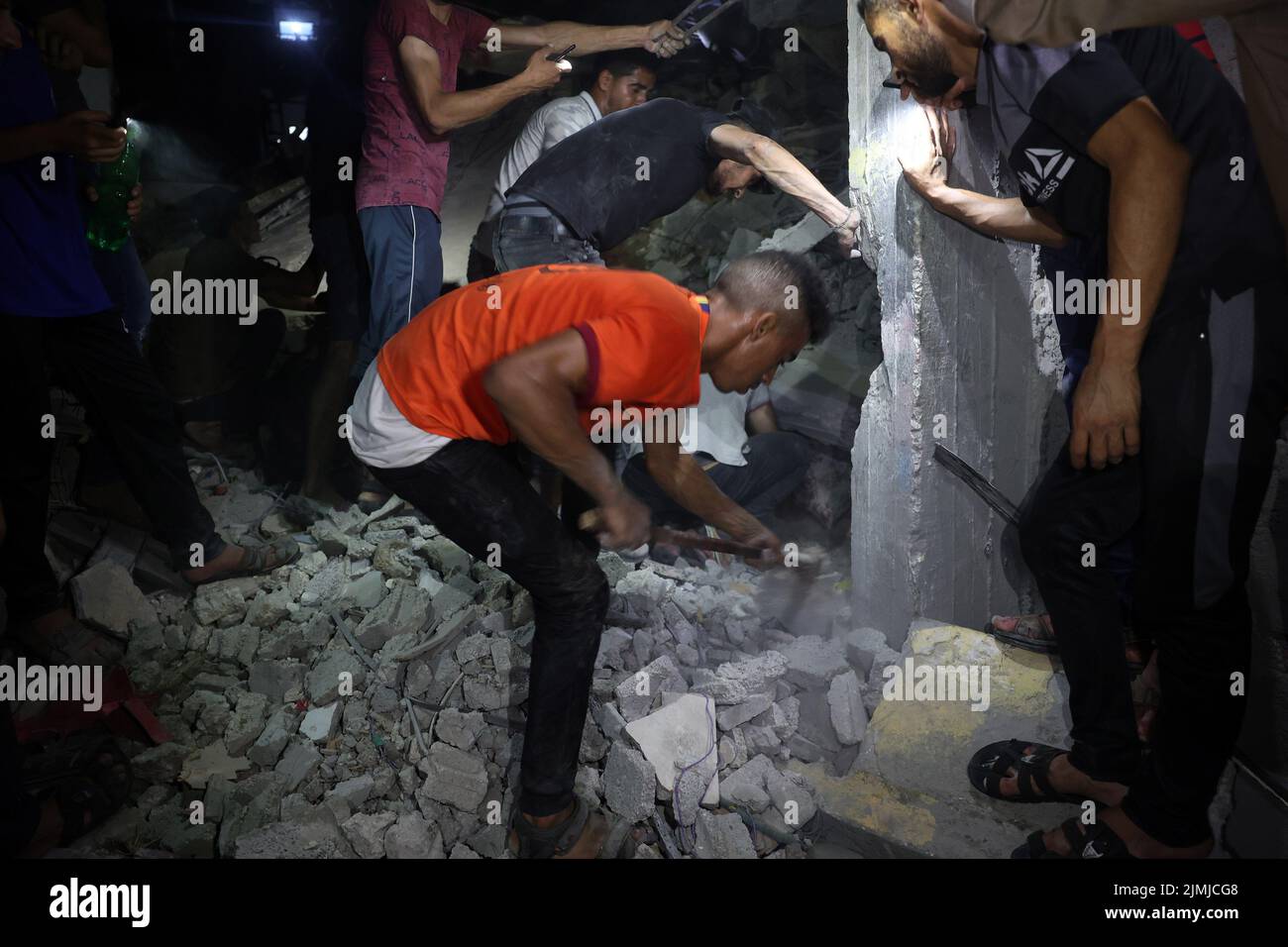 Palestinians search for casualties in the rubble of a residential ...