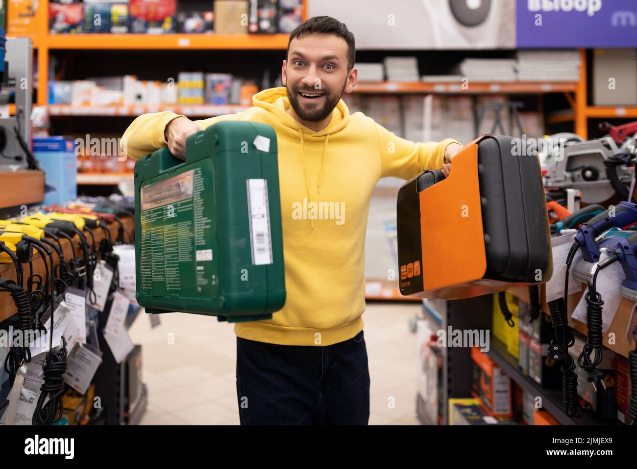 A satisfied customer in a hardware store who purchased a drill and a ...