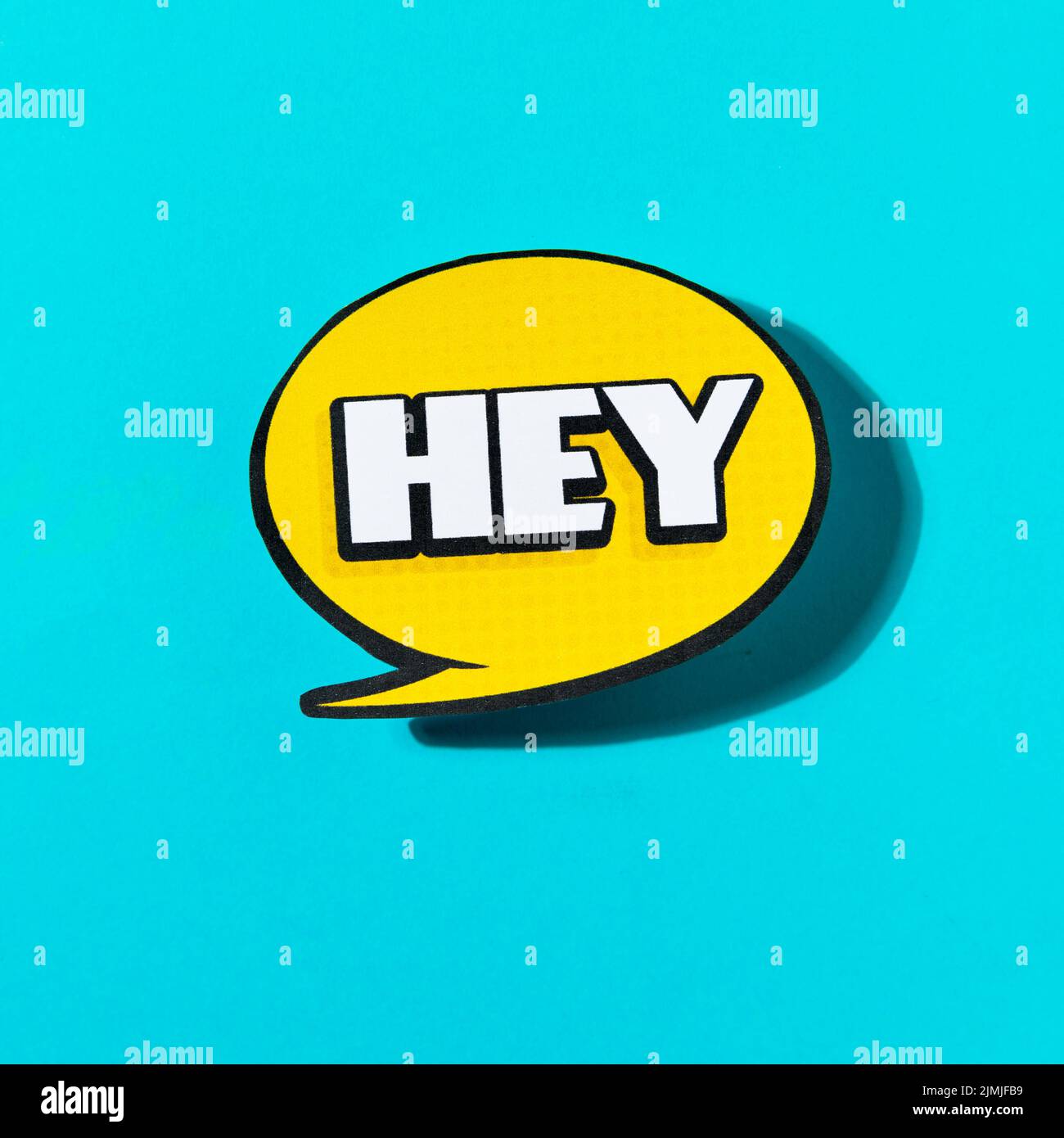 Hey text yellow speech bubble blue background Stock Photo - Alamy