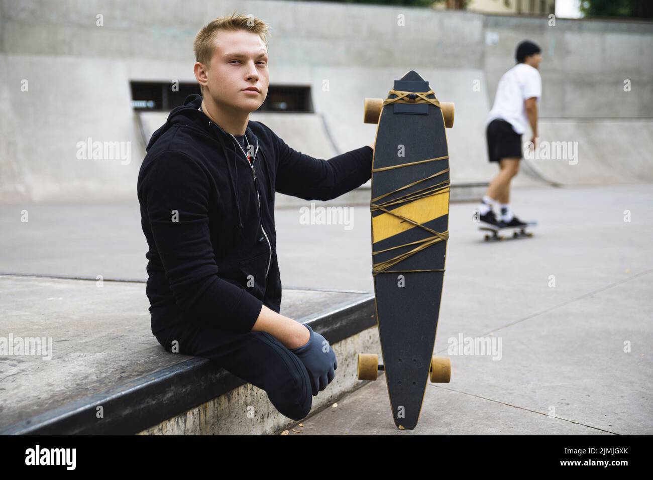 Motivated handicapped guy with a longboard in the skatepark Stock Photo ...