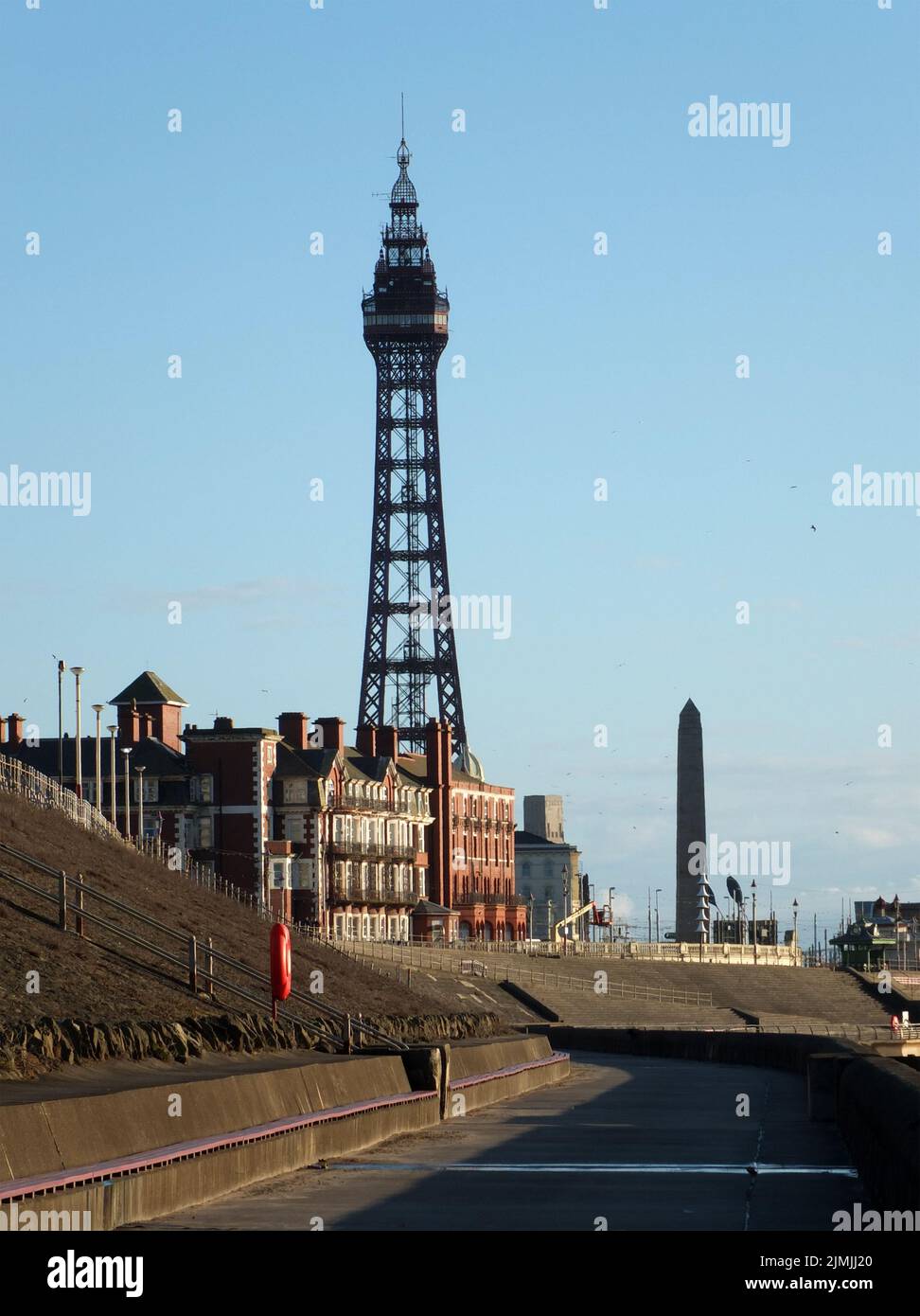 View of blackpool tower from the promenade with town buildings in ...
