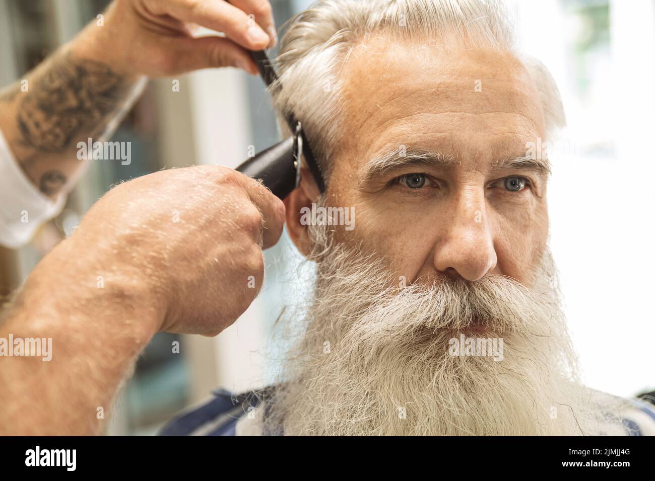 Hairdresser making stylish haircut for a handsome old man Stock Photo ...