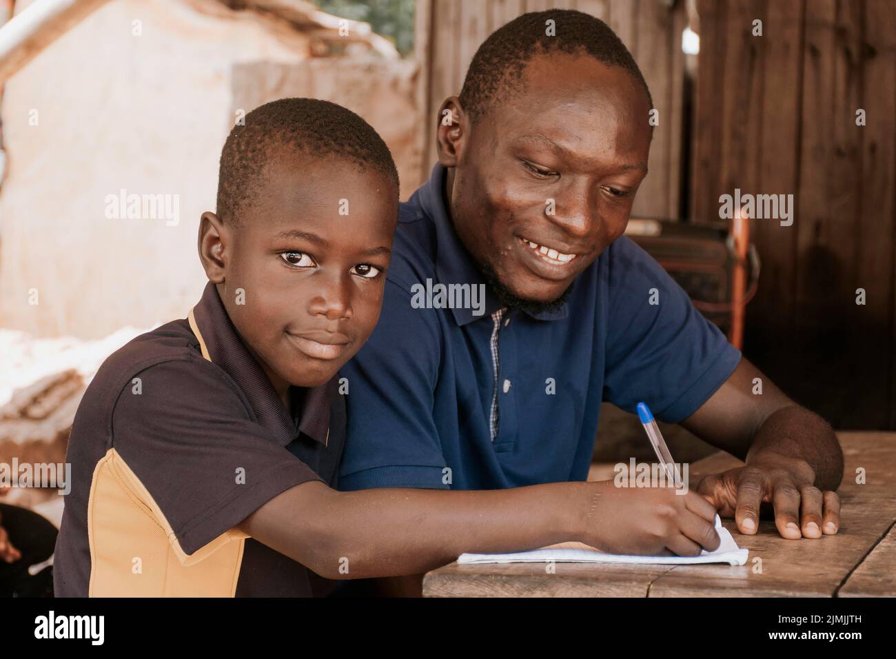 Medium shot smiley kid writing Stock Photo - Alamy