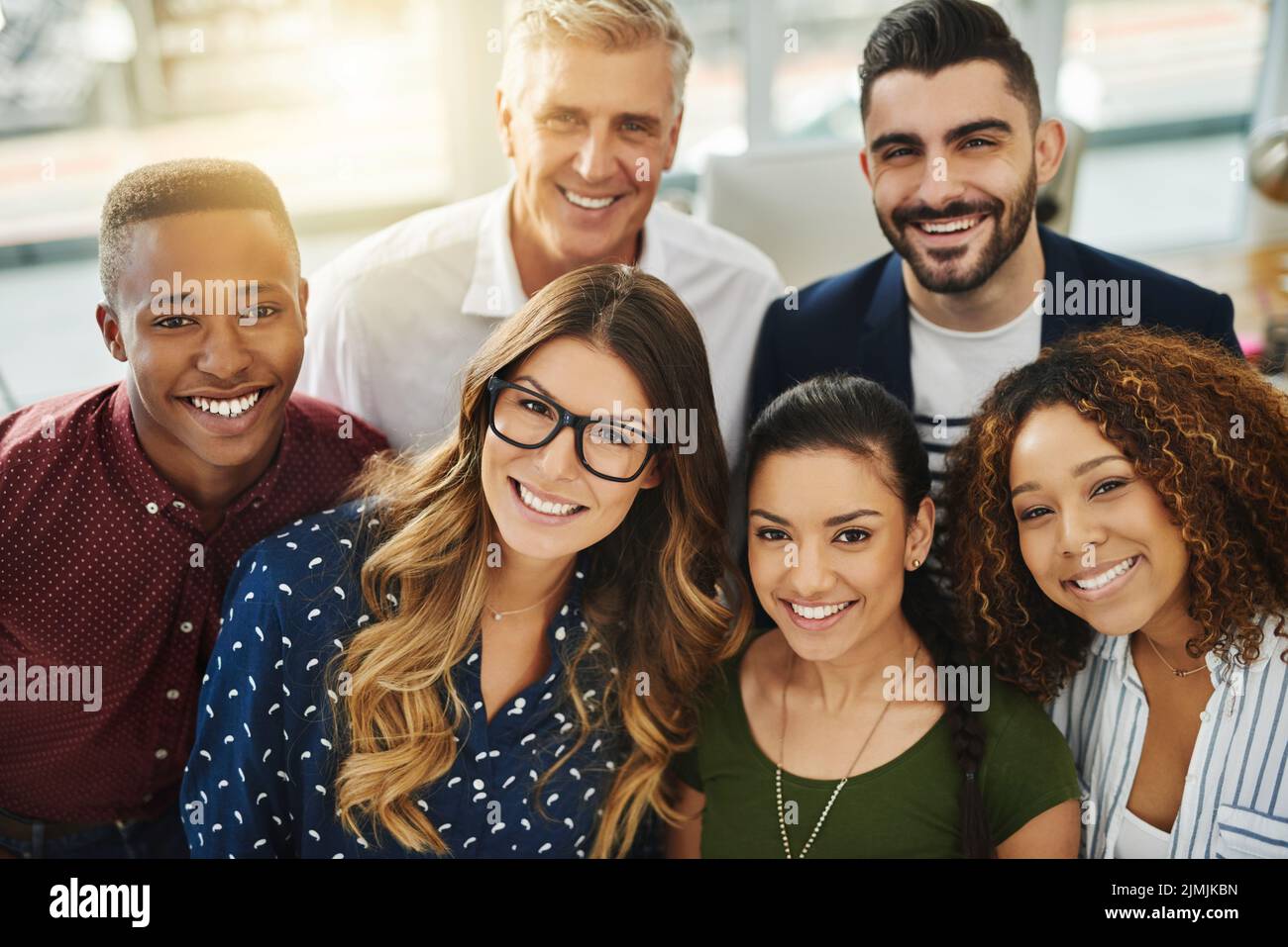 Teamwork, smiling and diverse workers standing together in a creative ...